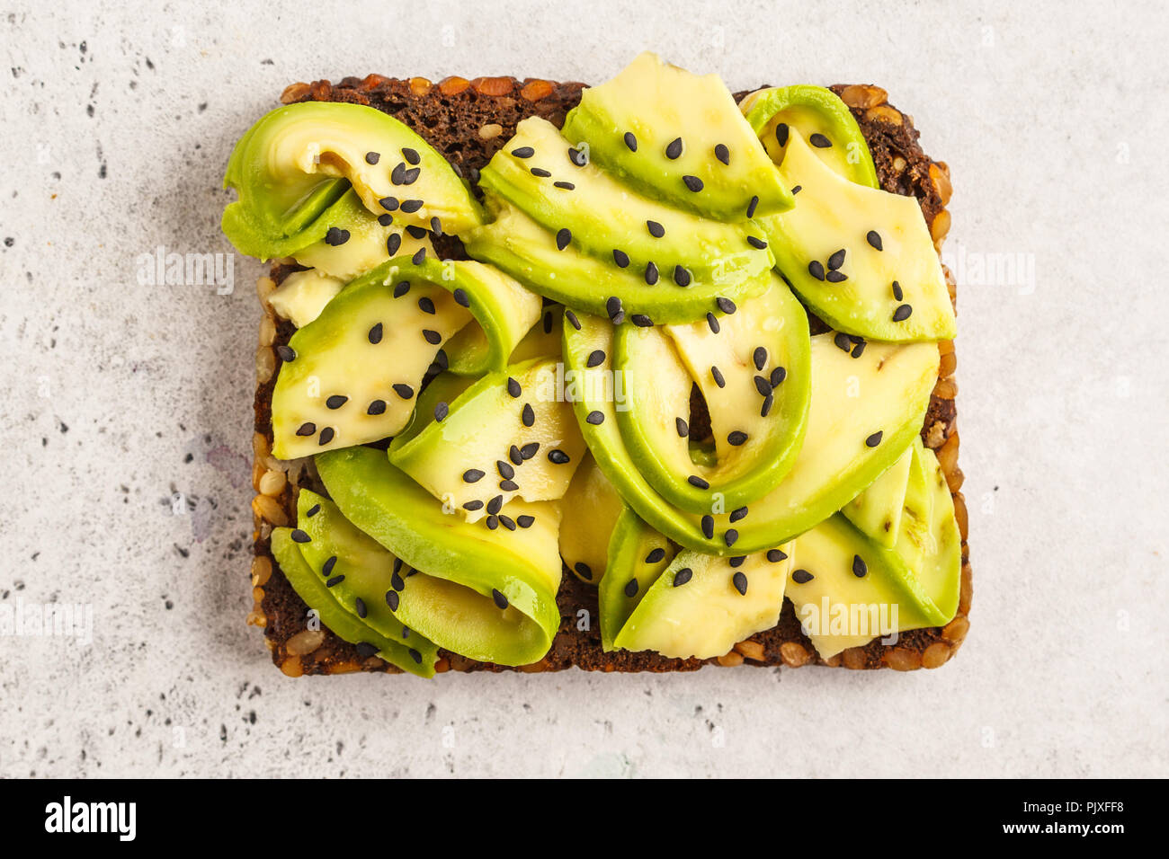 Avocado toast on a healthy sesame bread with sesame seeds on white ...