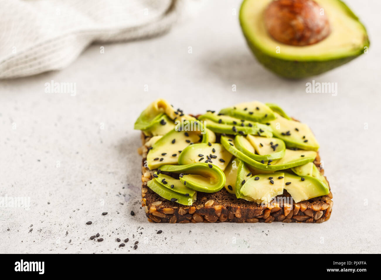 Avocado toast on a healthy sesame bread with sesame seeds on white ...