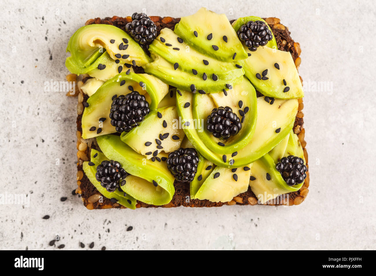 Avocado toast on a healthy sesame bread with sesame seeds on white ...