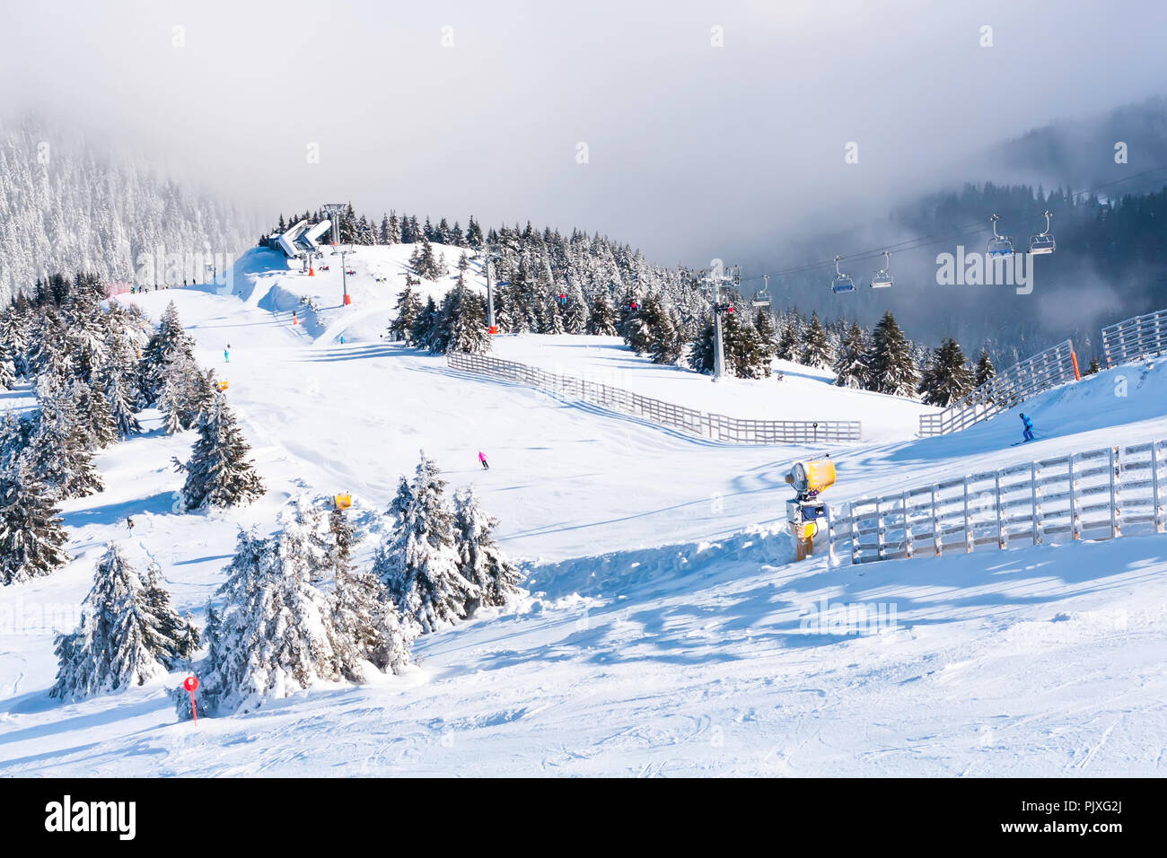 Ski resort, ski slope, ski lift, pine trees and fog mountains panorama ...