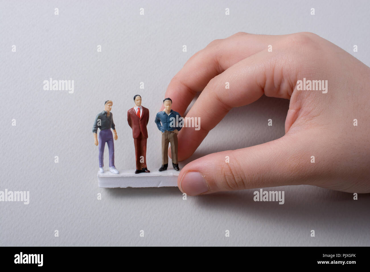 Tiny figurines of men miniature model in hand Stock Photo - Alamy