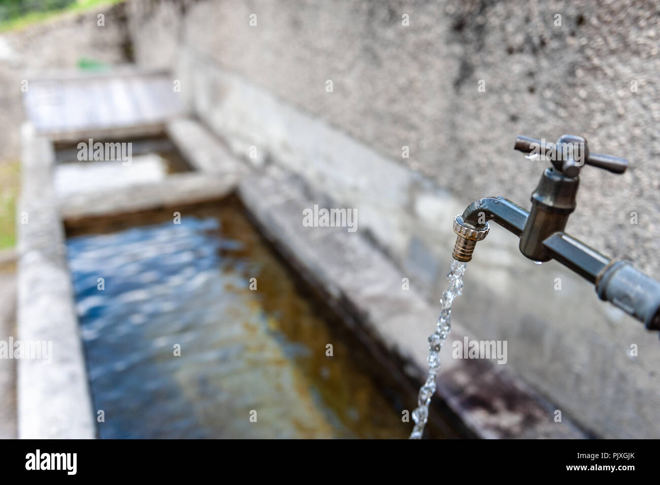 A tap from a drinking water fountain in the village of Santa Fosca, in ...