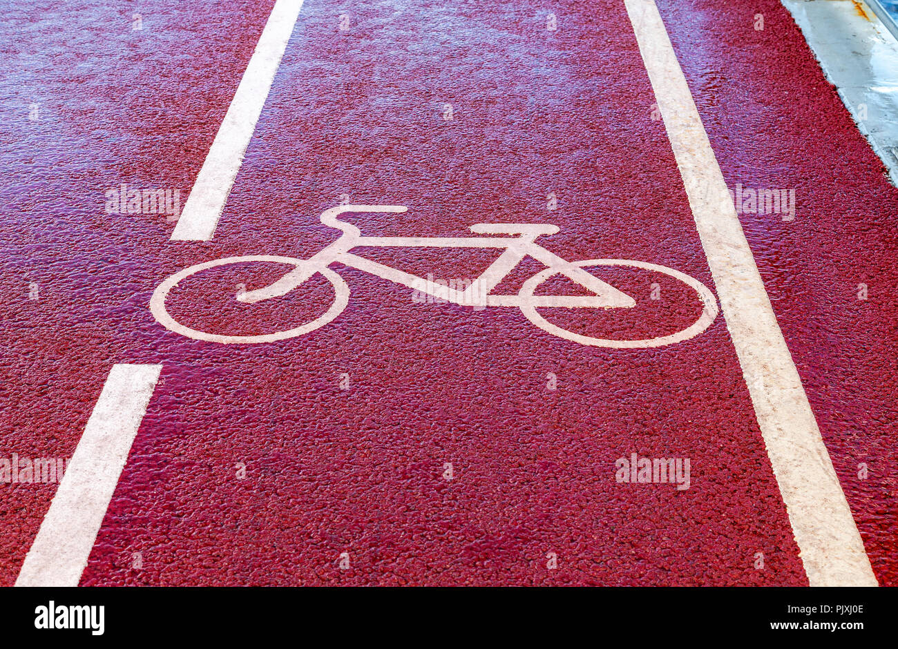 Bike lane with road symbol painting on red asphalt Stock Photo - Alamy