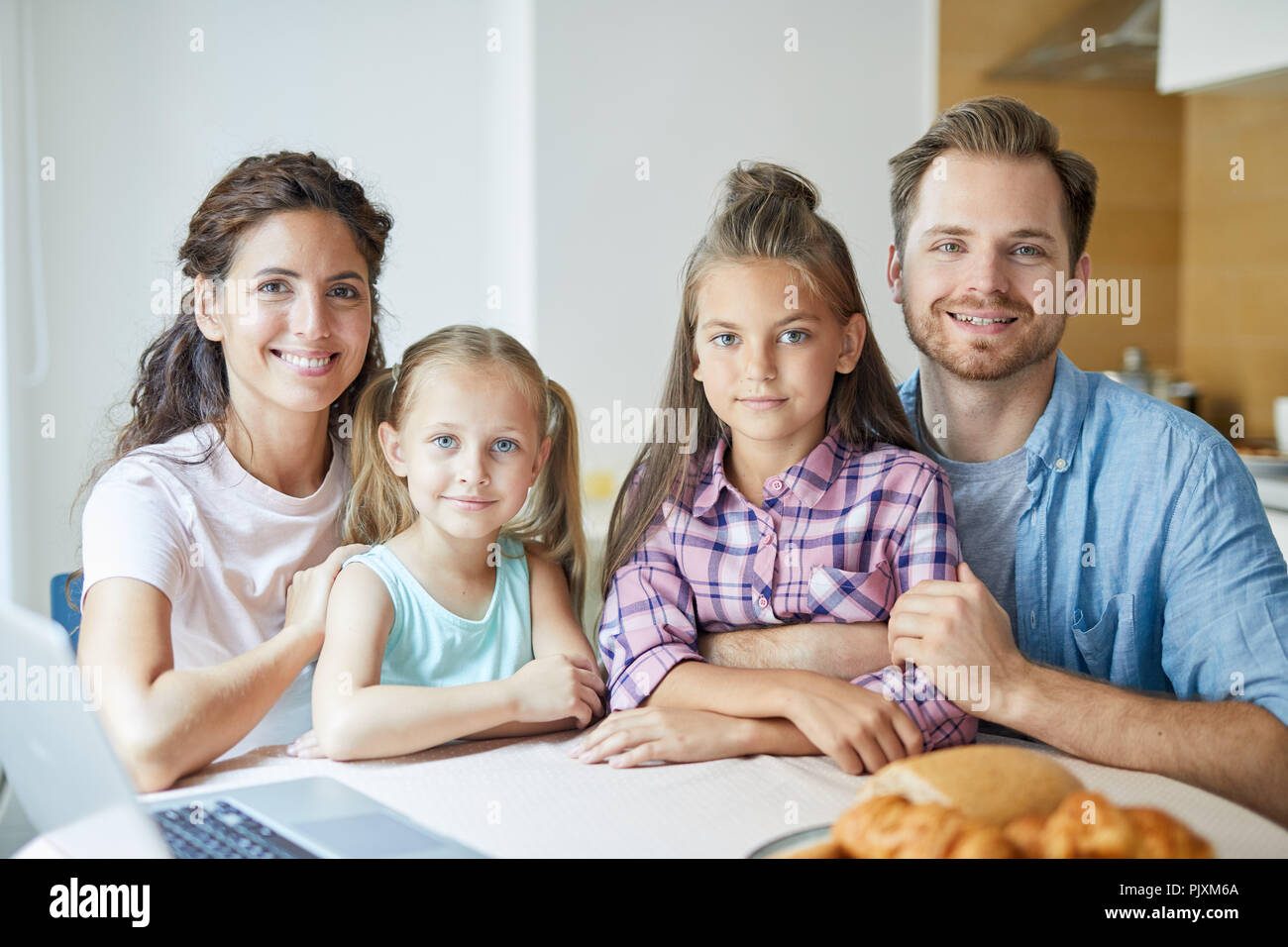 Family by table Stock Photo - Alamy