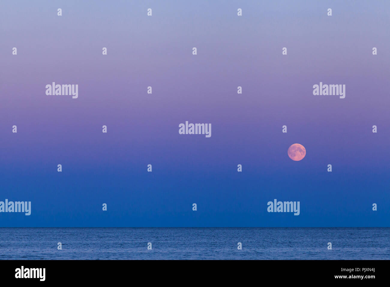 Full moon, a lunar phase, on the colorful sky. Late evening up North ...