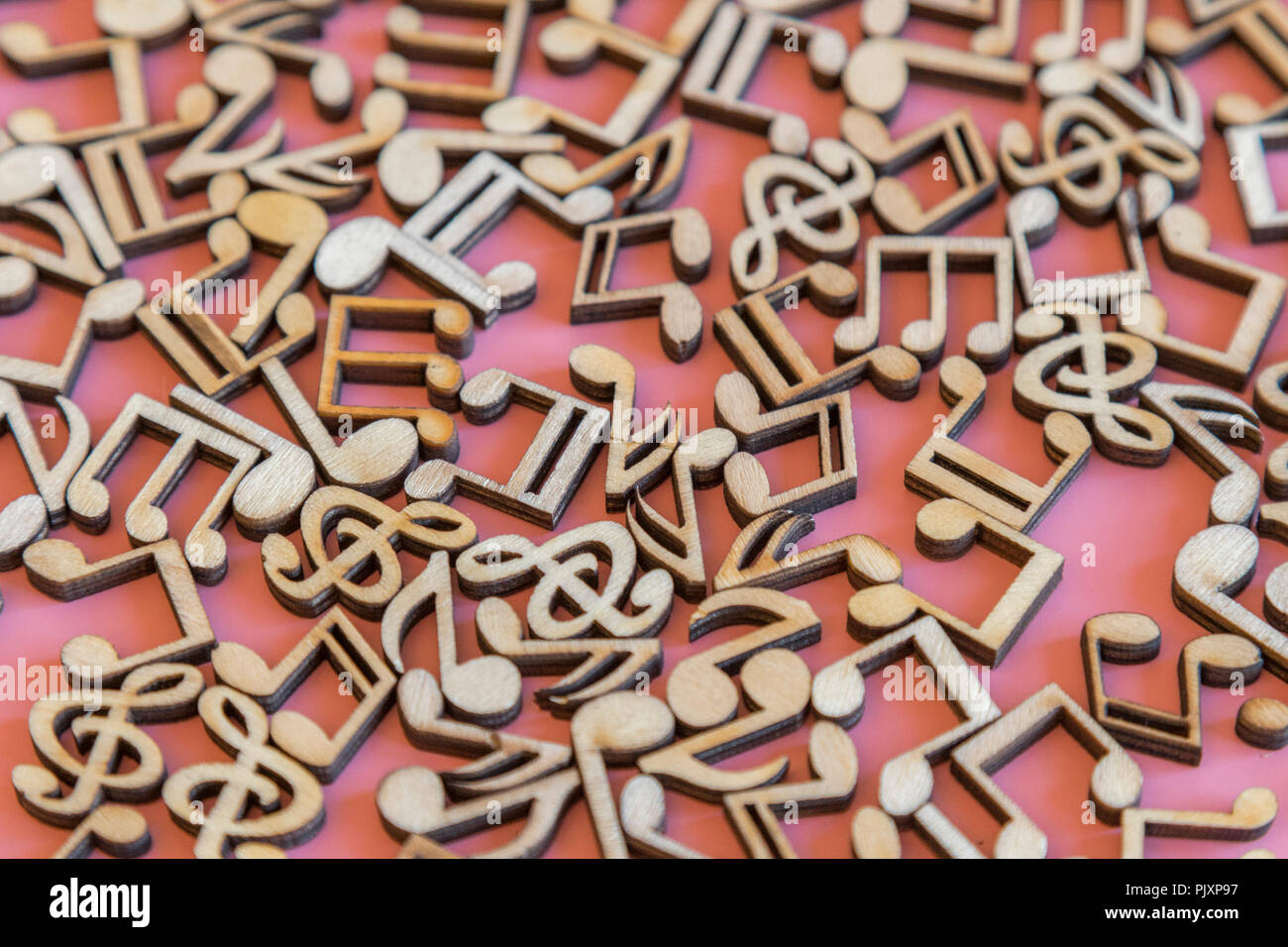 background of music. background of music. Wooden notes on a pink ...