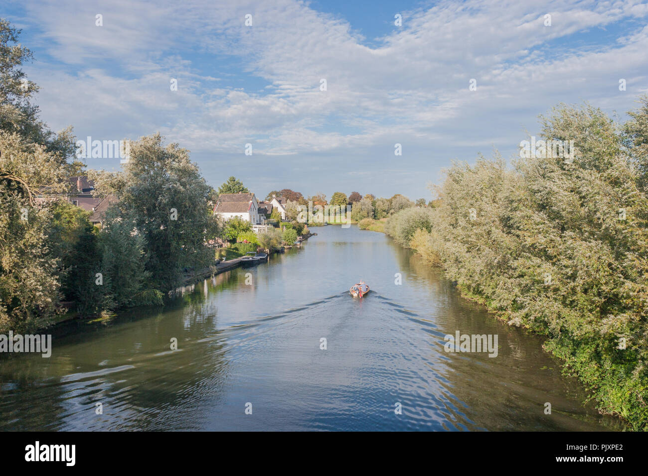 A boat glides down the Linge River in Tricht, the Netherlands on a ...