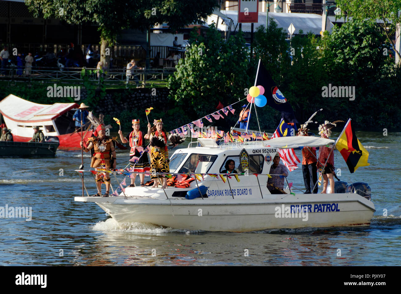 Kuching, Sarawak river, boats with natives in traditional dress form ...