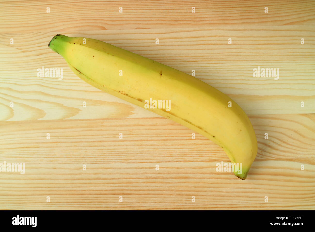 One Vibrant Yellow Ripe Fresh Banana Isolated on Wooden Background with ...