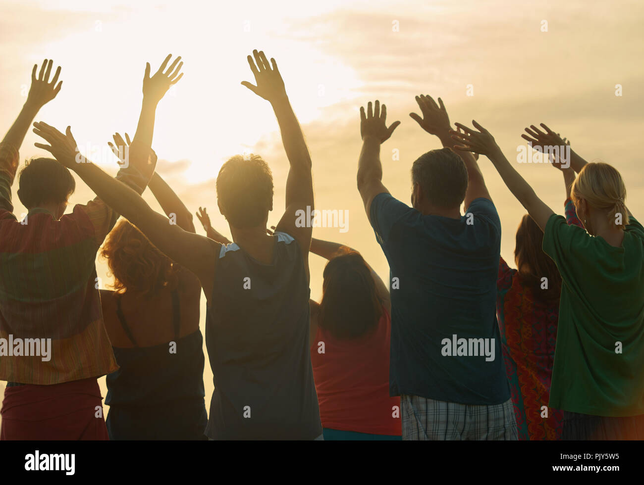 Hands up against sunrise background Stock Photo - Alamy