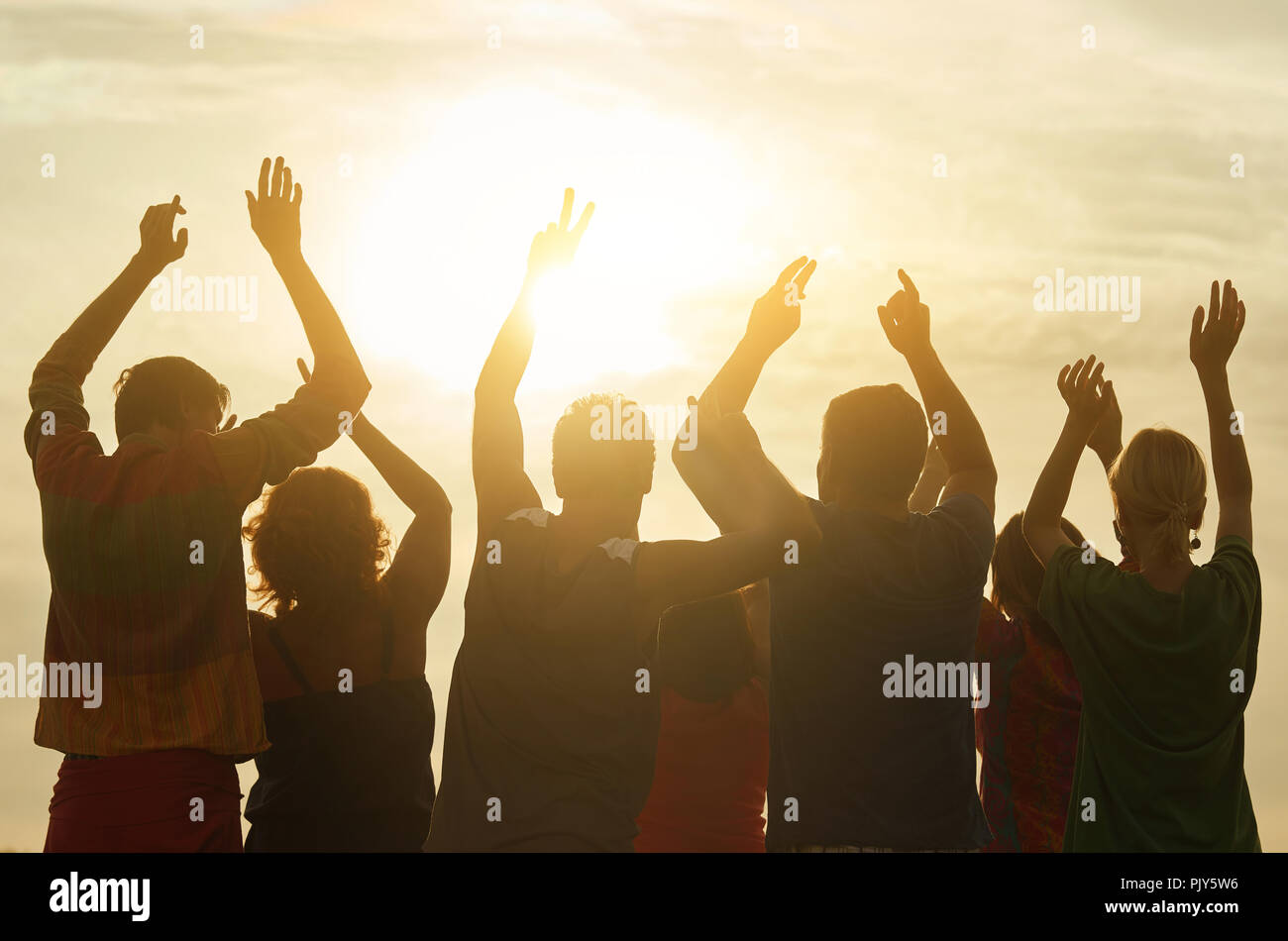 Happy people put hands up, back view Stock Photo - Alamy