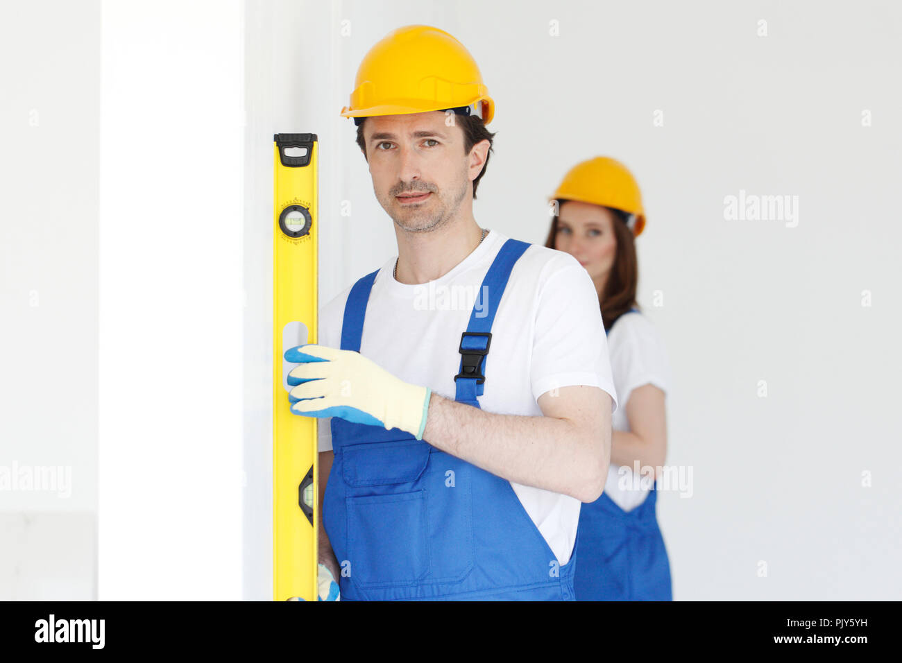 Team of workmen align wall using tools Stock Photo - Alamy