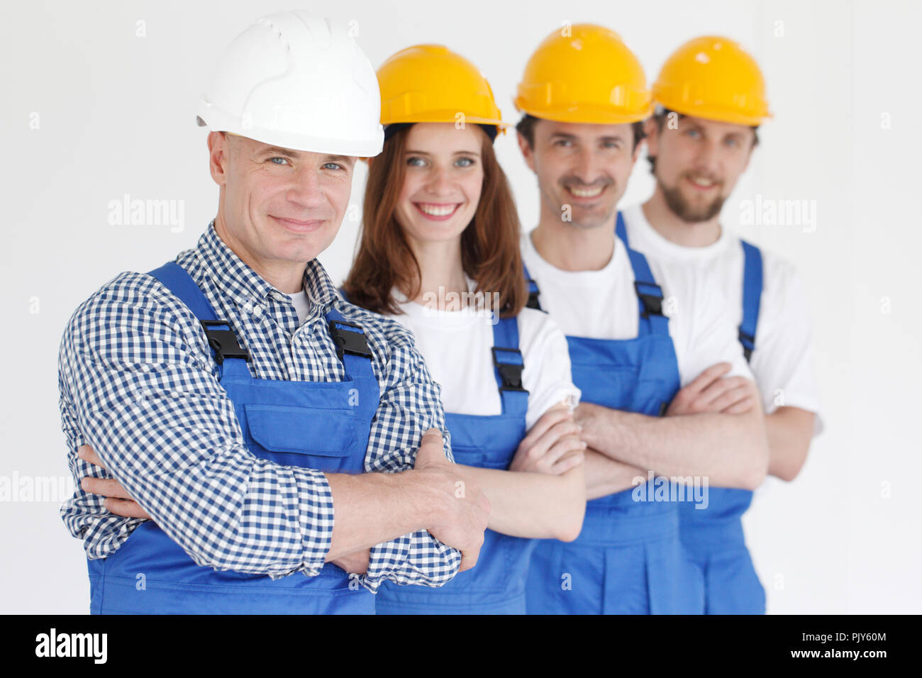 Group portrait of construction workers standing in a row and smiling ...