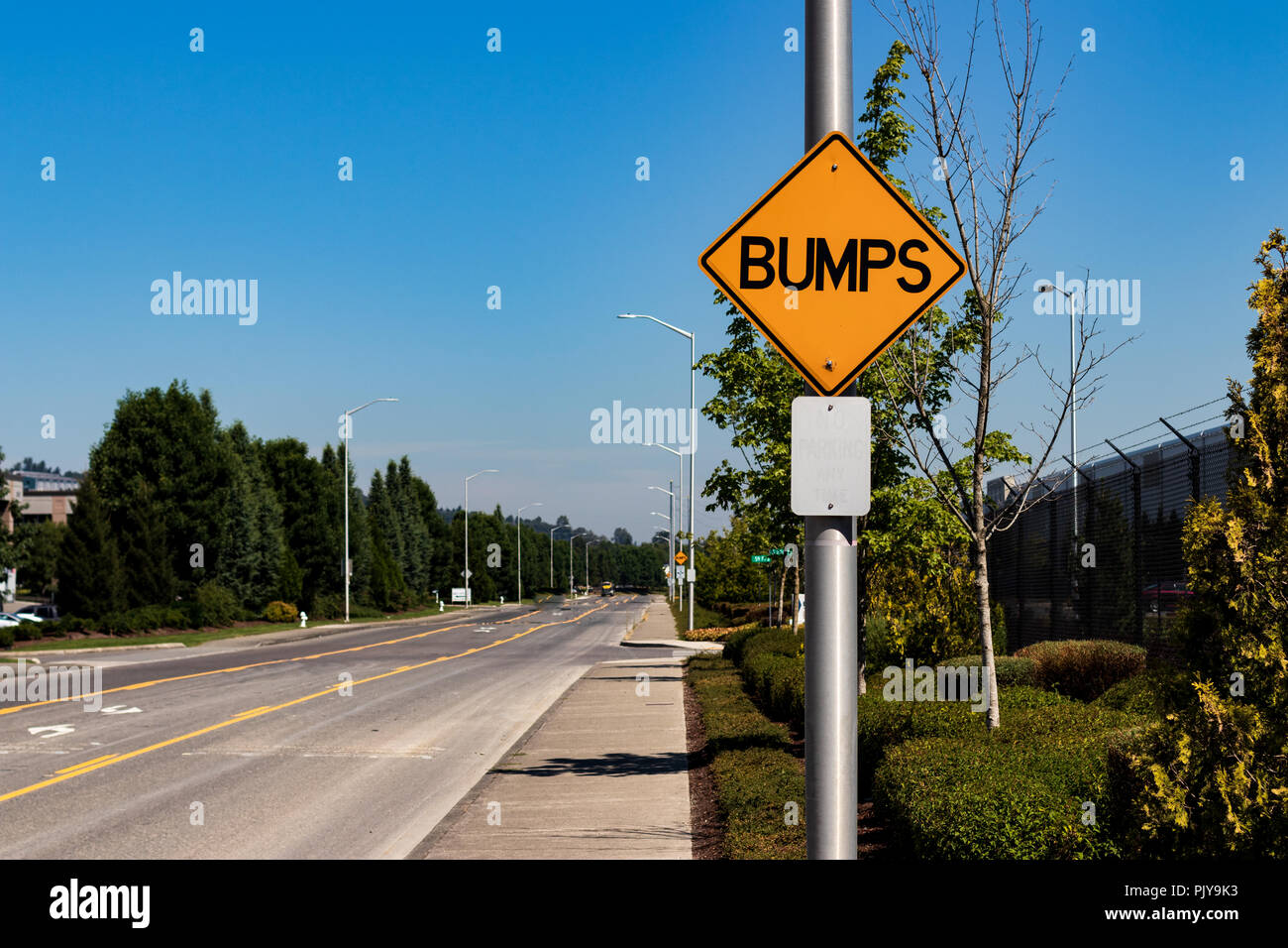 Bumps road sign next to an industrial byway and a blue sky Stock Photo ...