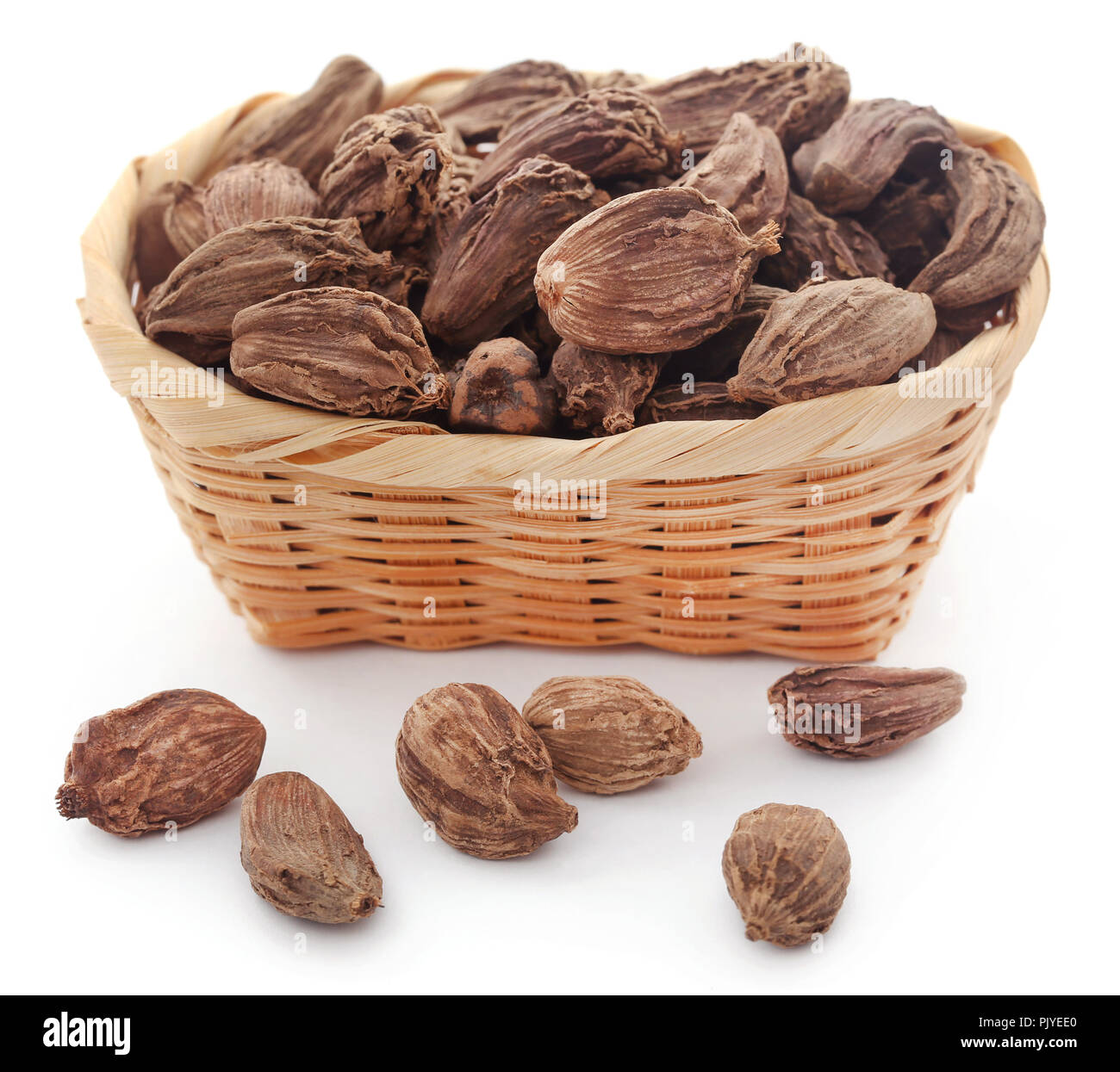 Black cardamom in a basket over white background Stock Photo - Alamy