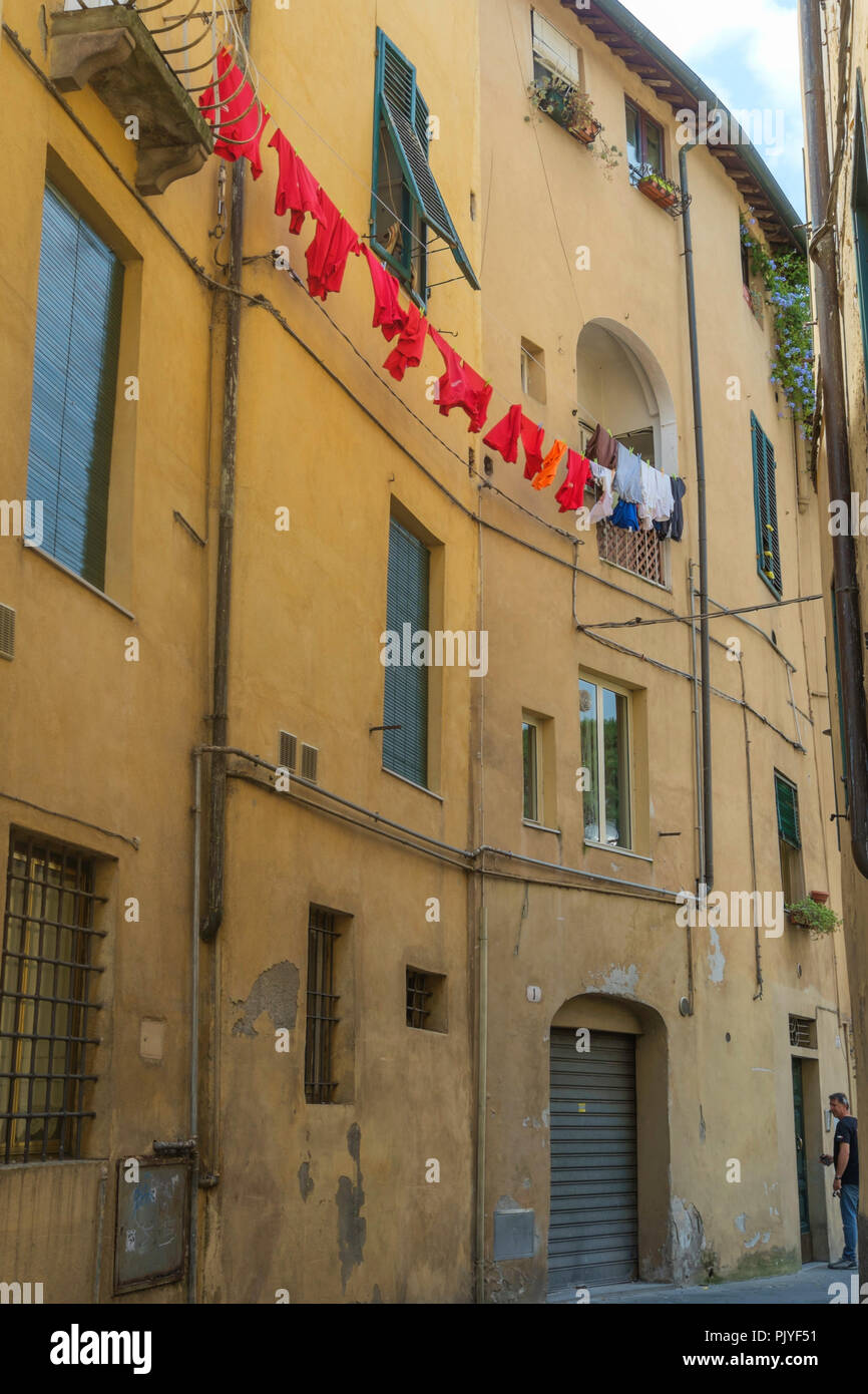 Clothes drying on a clothesline outside a window in a side street in ...