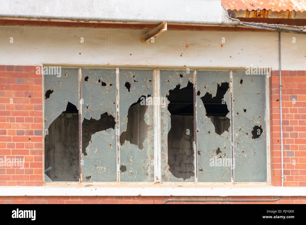 A close up view of old broken windows of the second floor of a ...