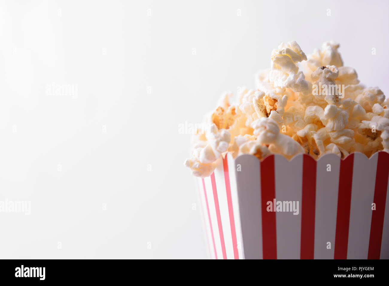 Popcorn in cardboard box with white background. Horizontal composition ...