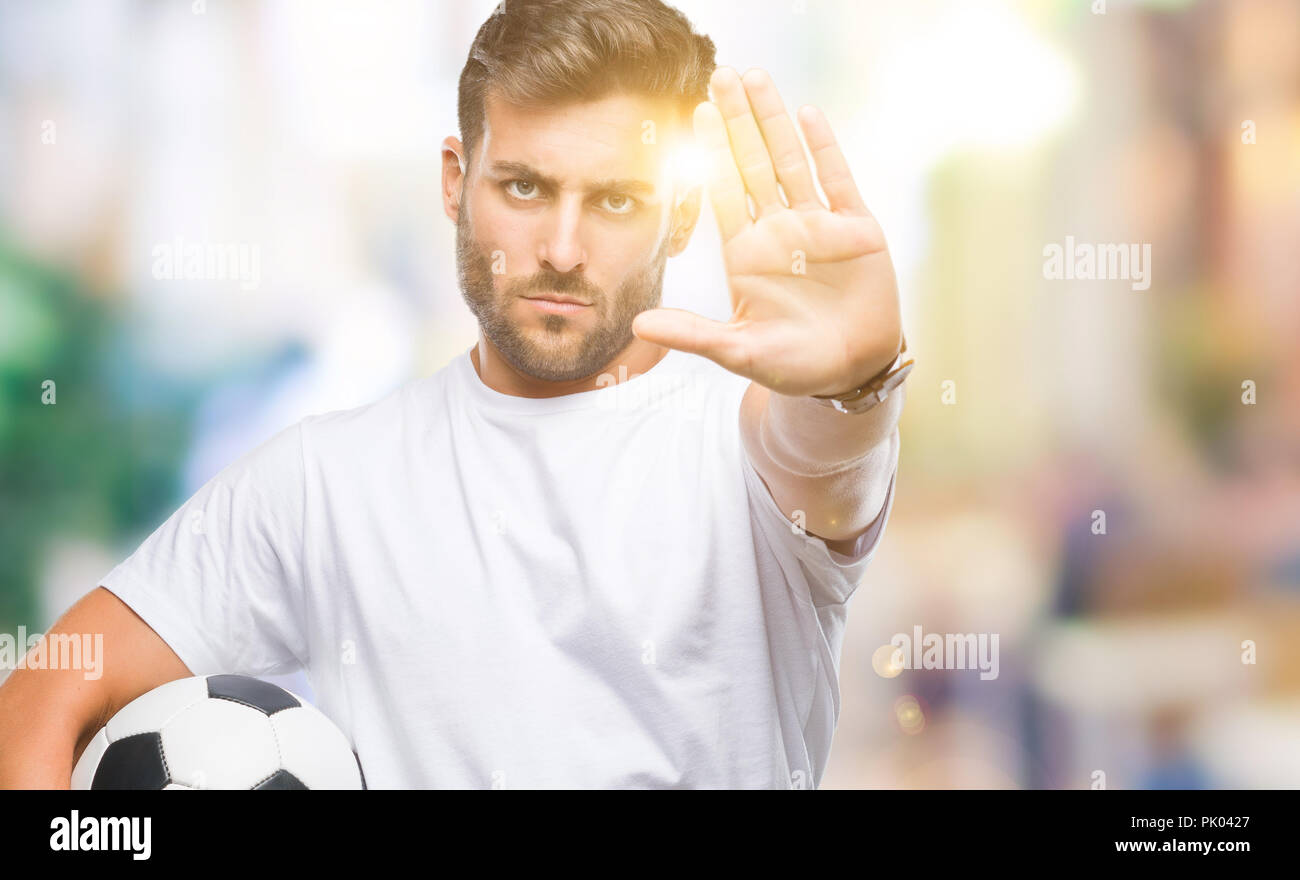 Young handsome man holding soccer football ball over isolated ...