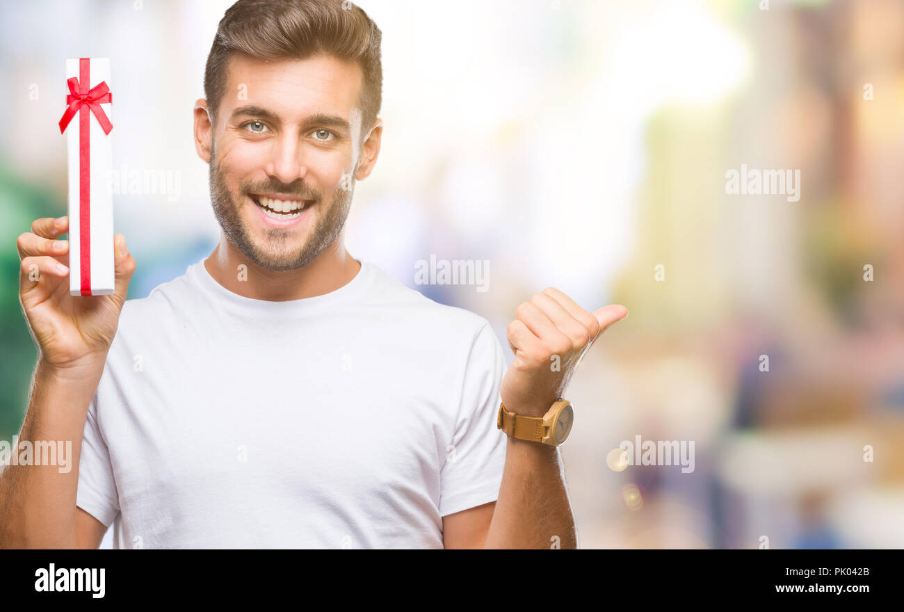 Young handsome man in love giving valentine present over isolated ...