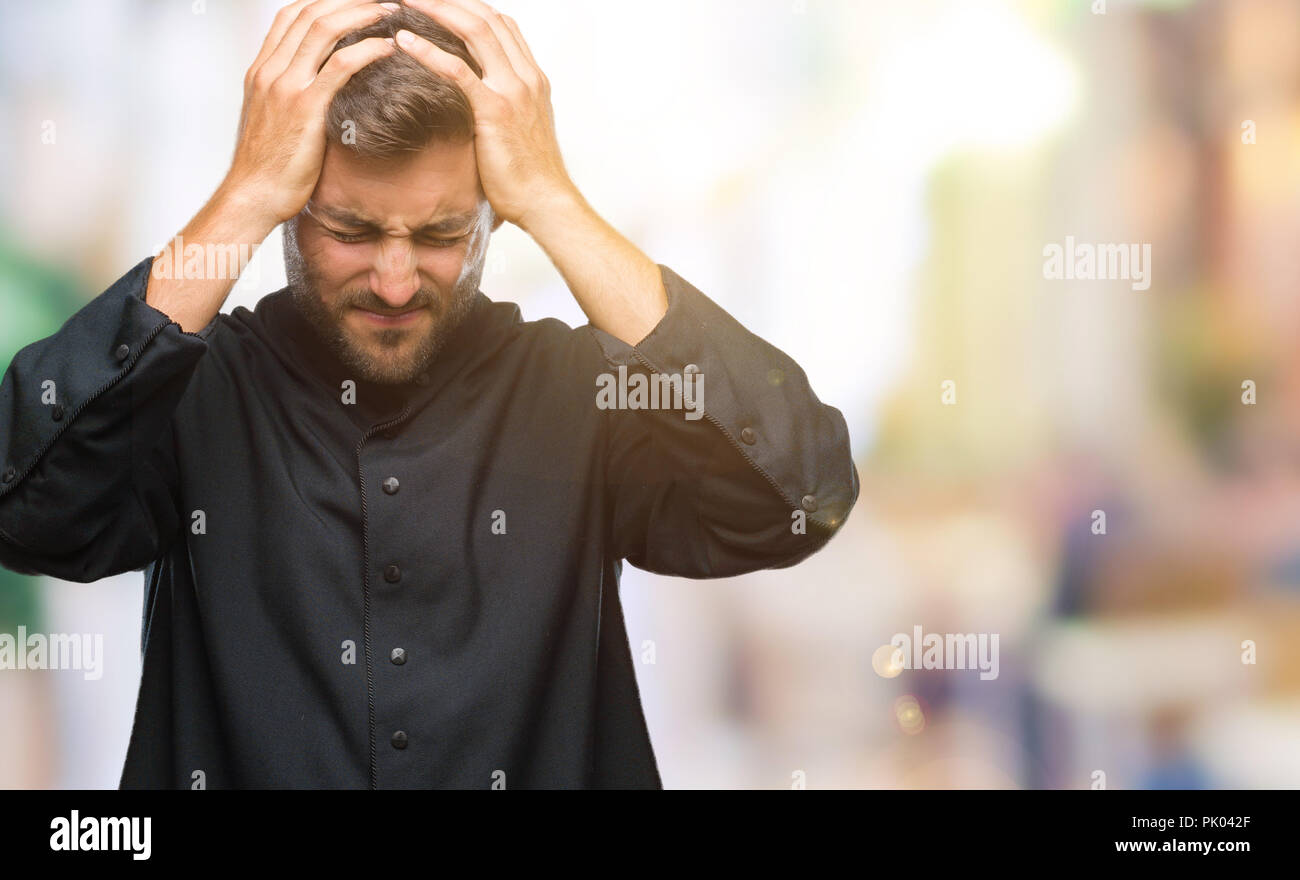 Young catholic christian priest man over isolated background suffering ...