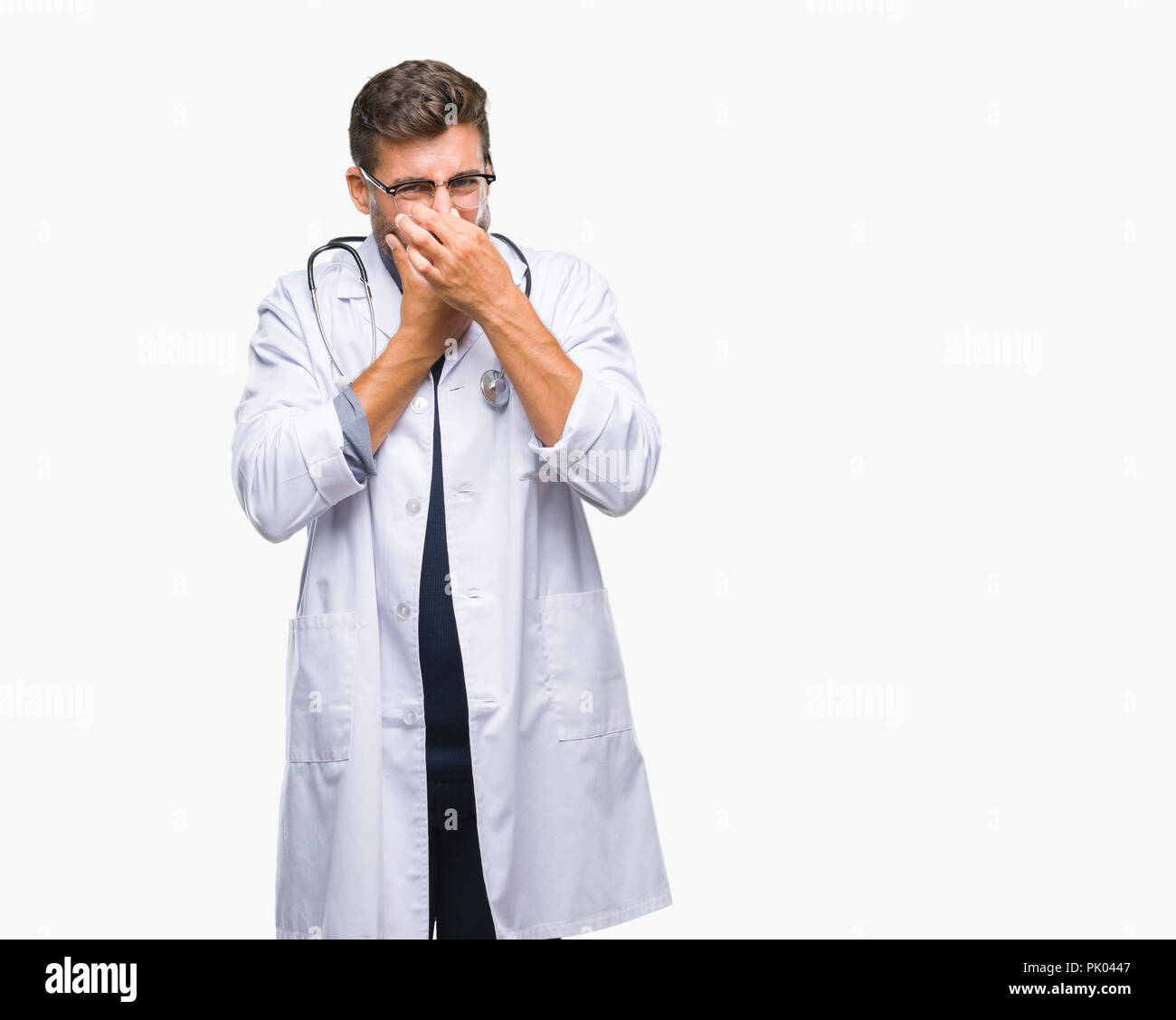Young handsome doctor man over isolated background smelling something ...