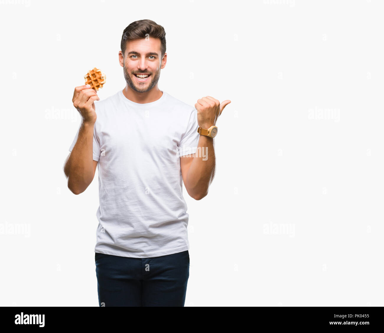 Young handsome man eating a sweet waffle over isolated background ...