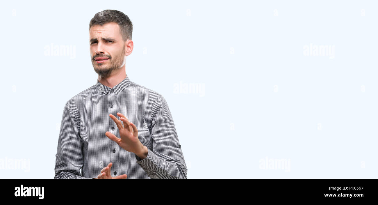 Young hipster man disgusted expression, displeased and fearful doing ...