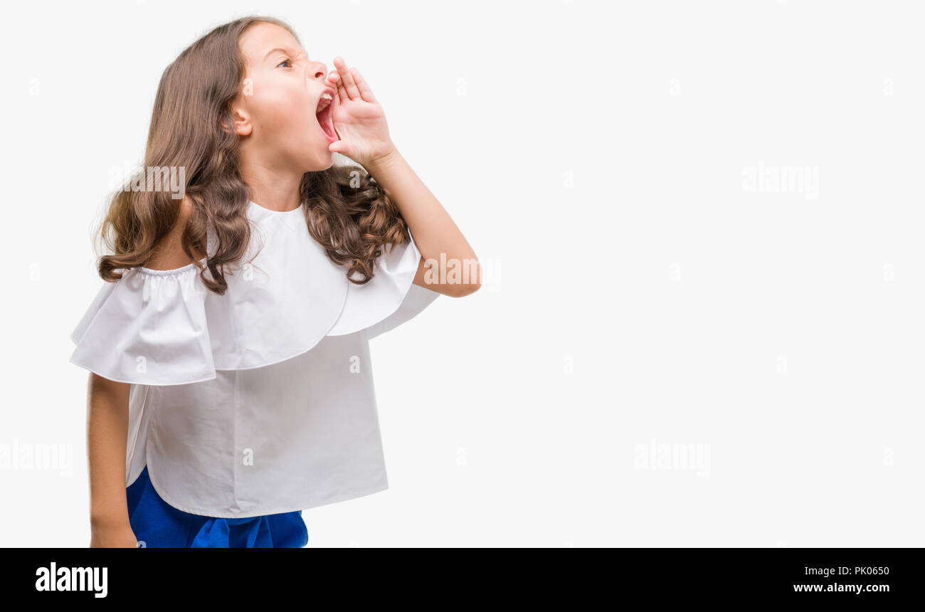 Brunette hispanic girl shouting and screaming loud to side with hand on ...