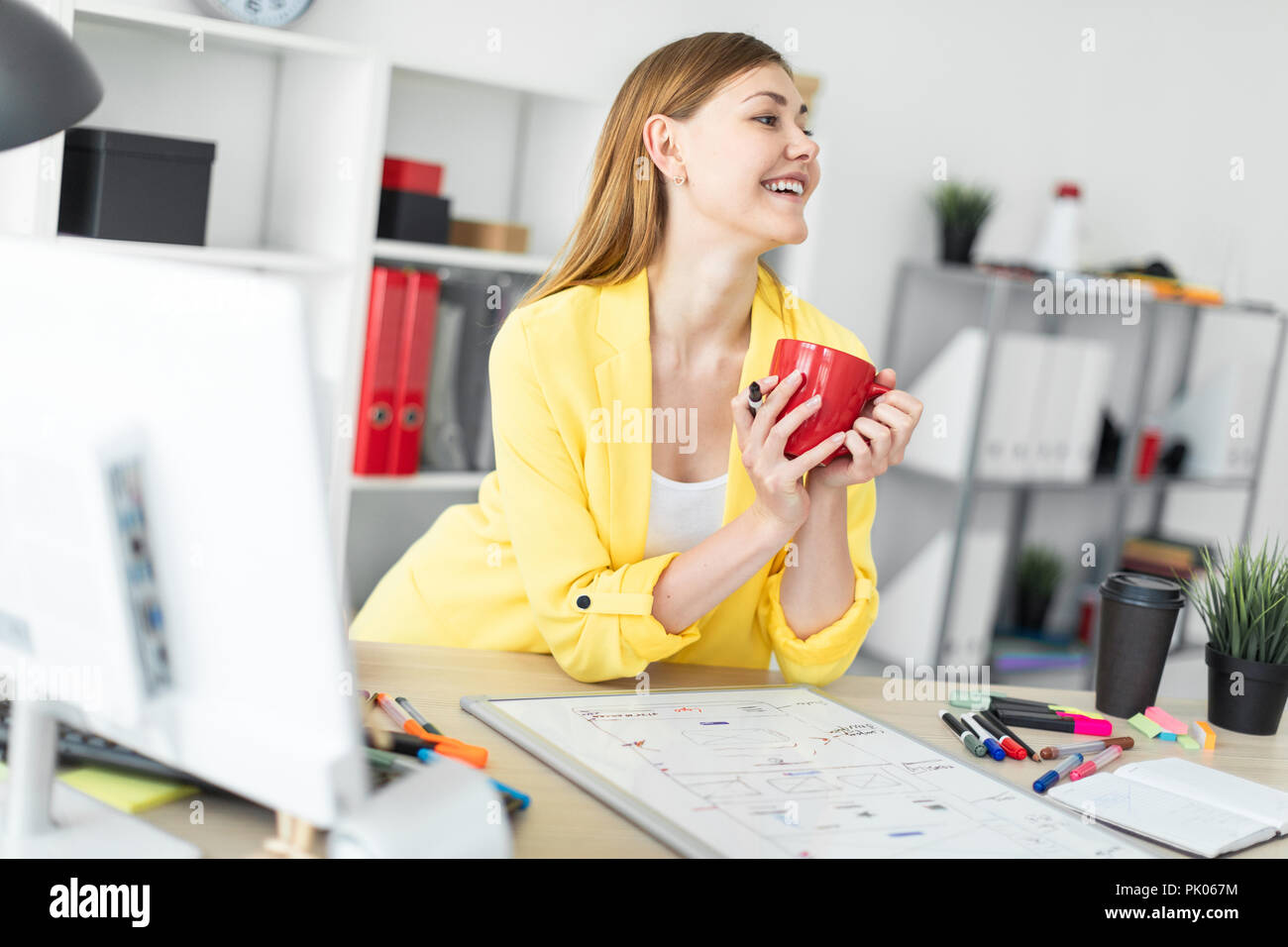 A beautiful young girl in a white T-shirt and a yellow jacket is ...