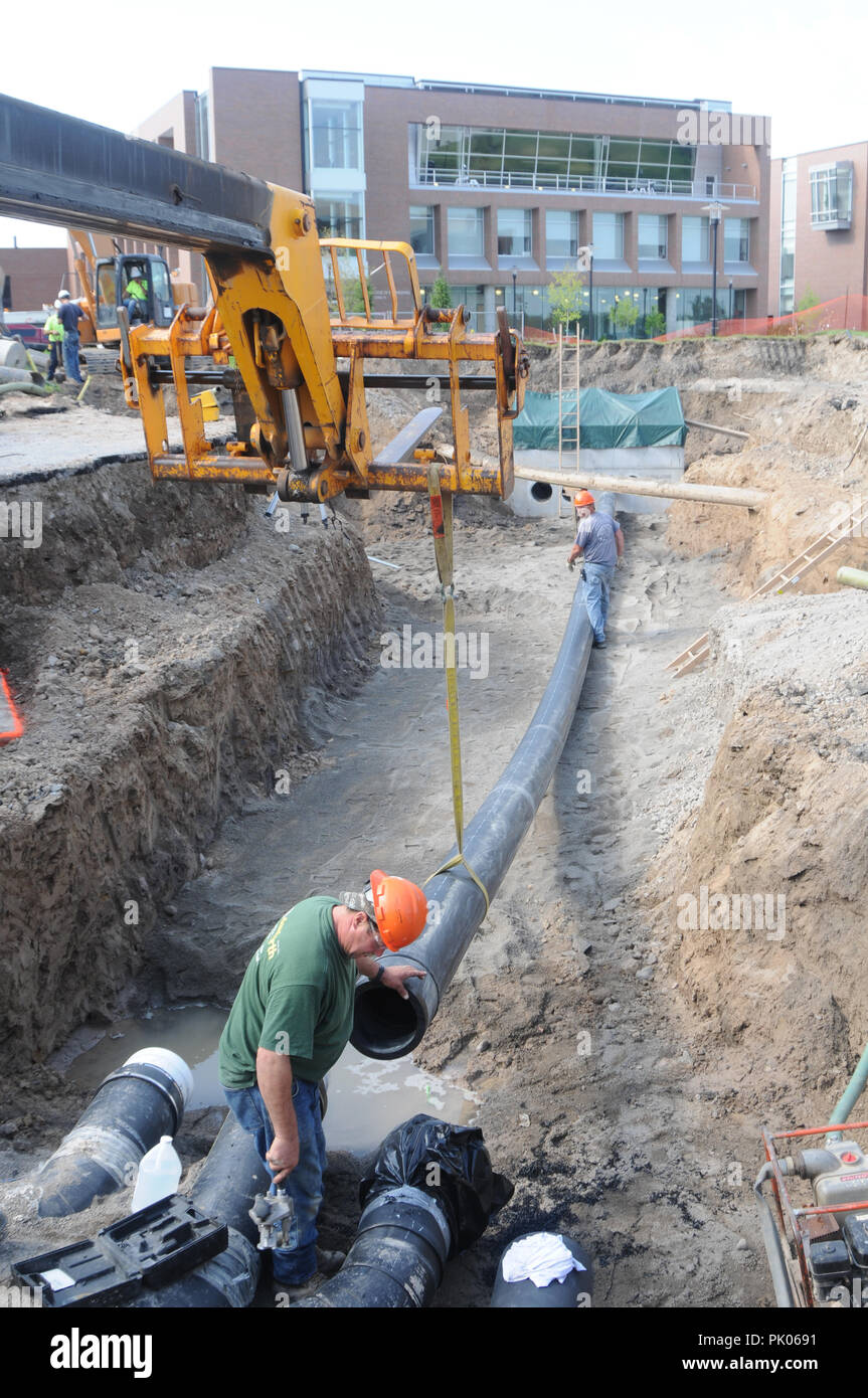 Laying pipe on a commercial construction site Stock Photo - Alamy