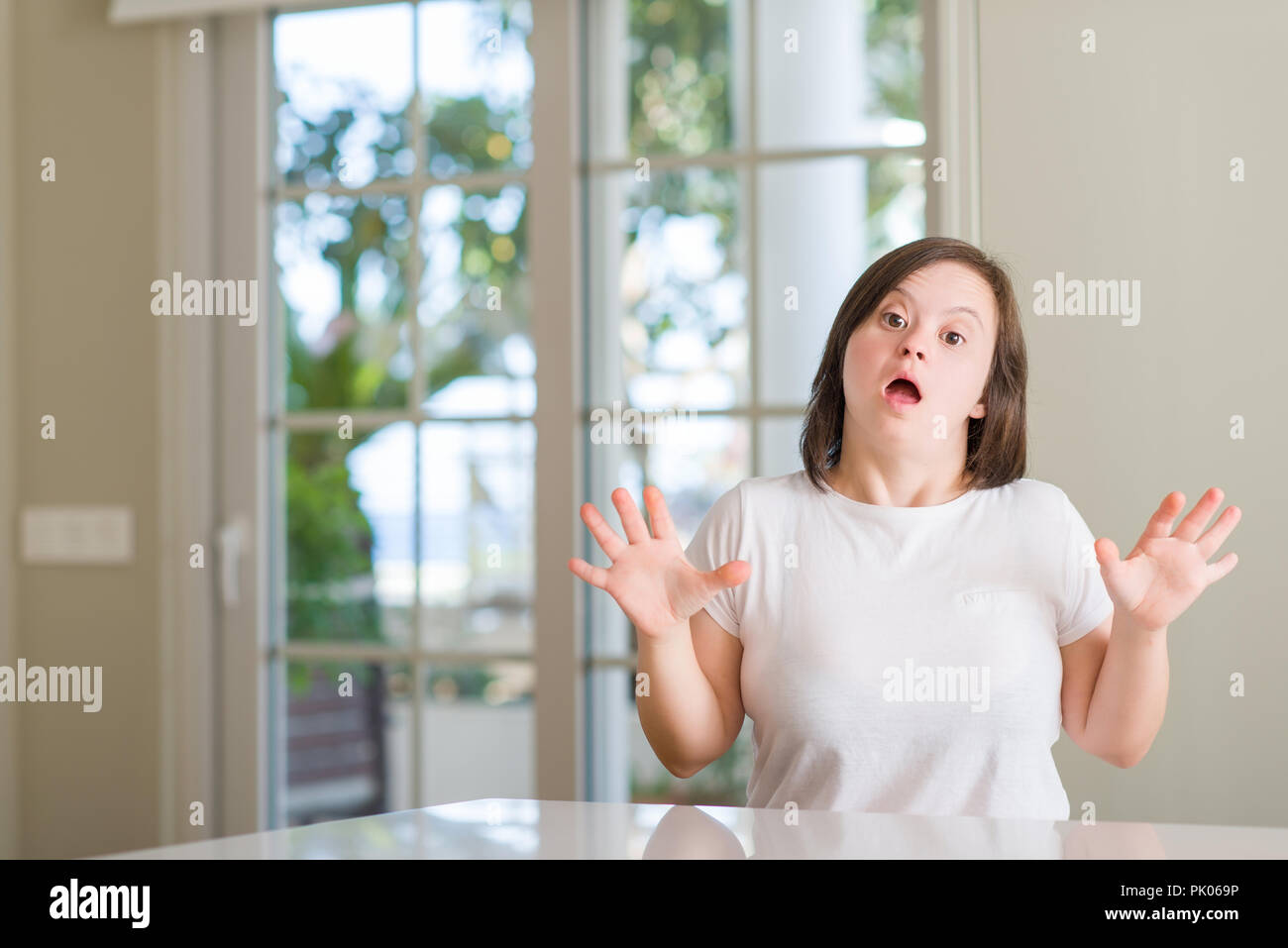 Down syndrome woman at home afraid and terrified with fear expression ...