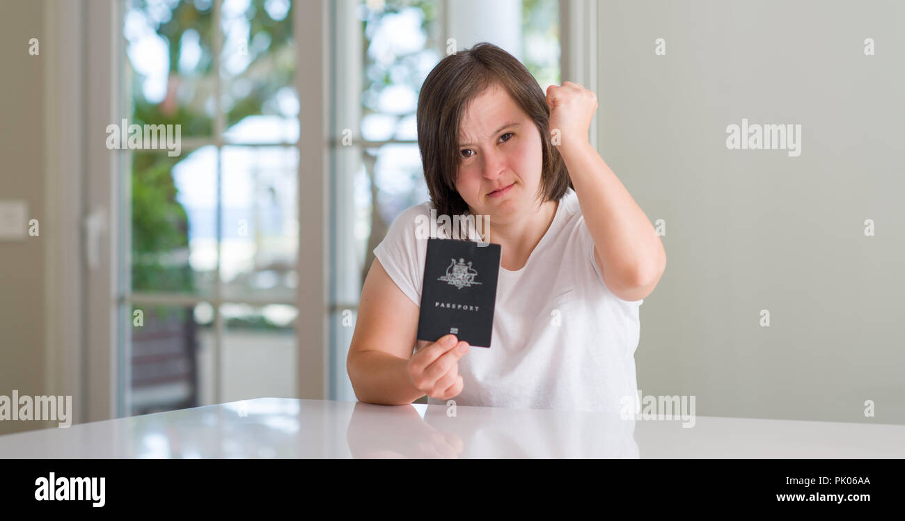 Down syndrome woman at home holding australian passport annoyed and ...
