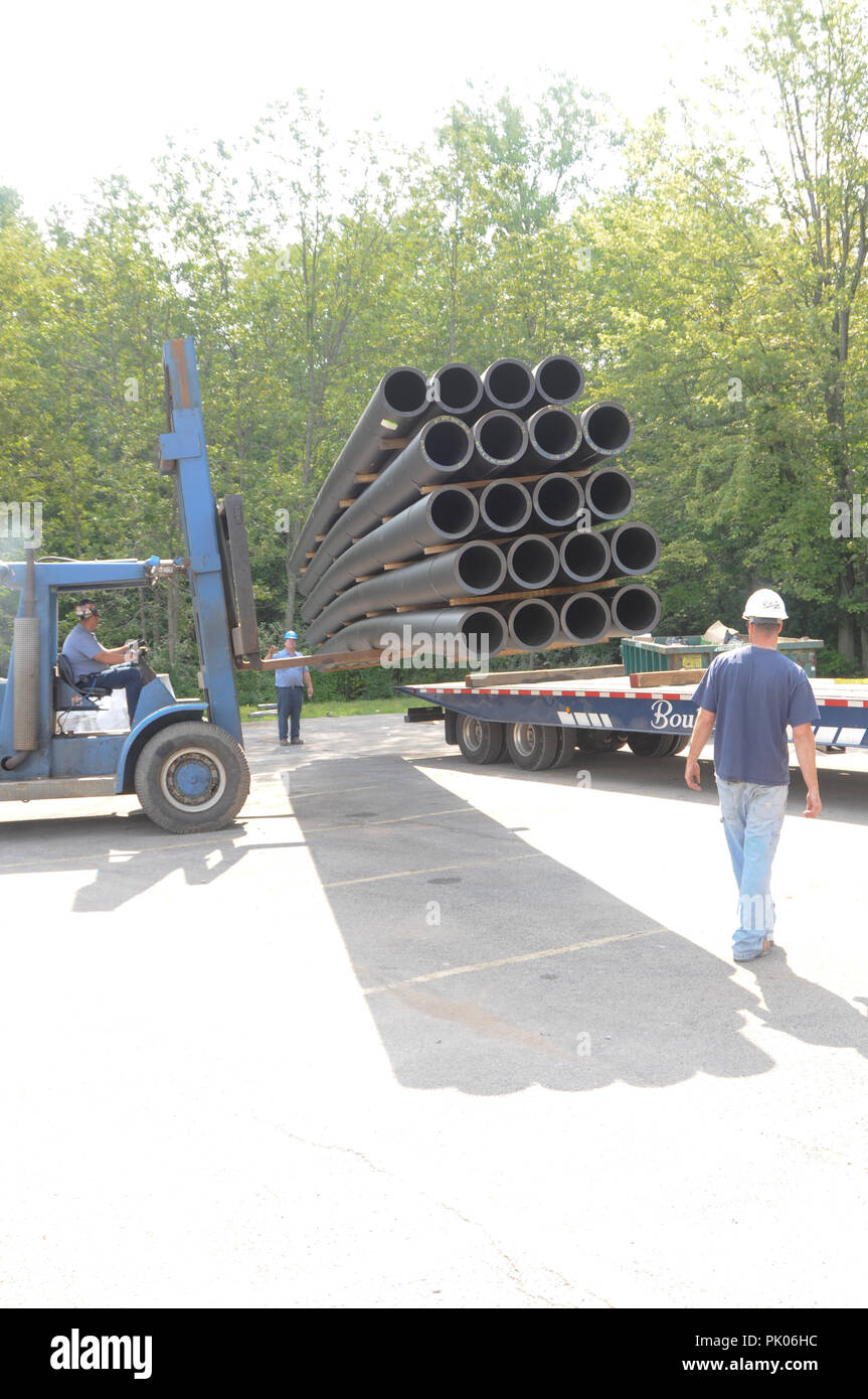 Moving pipes on a construction site Stock Photo - Alamy