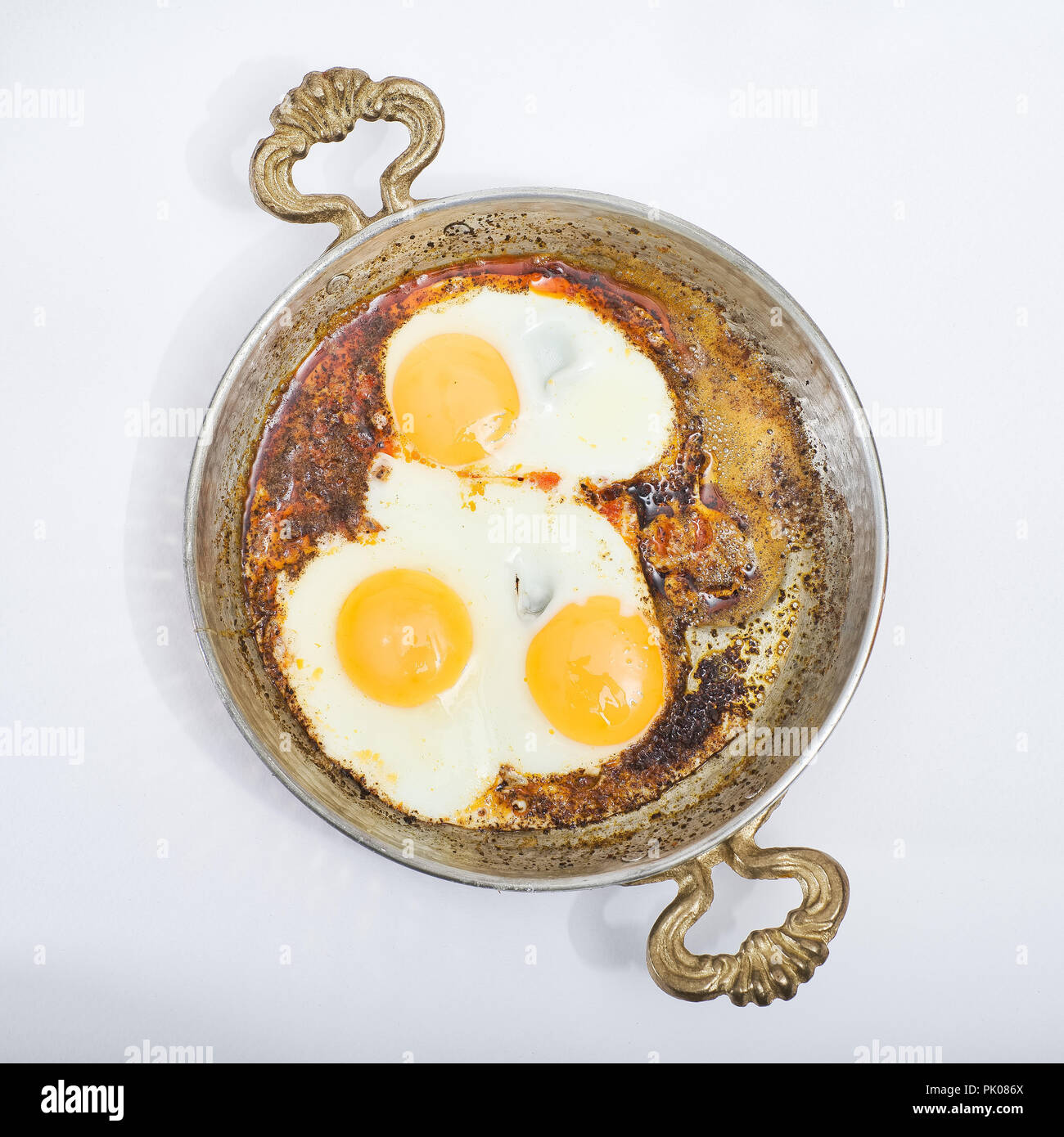3 Eggs in Copper Pan with Spice called isot Stock Photo - Alamy
