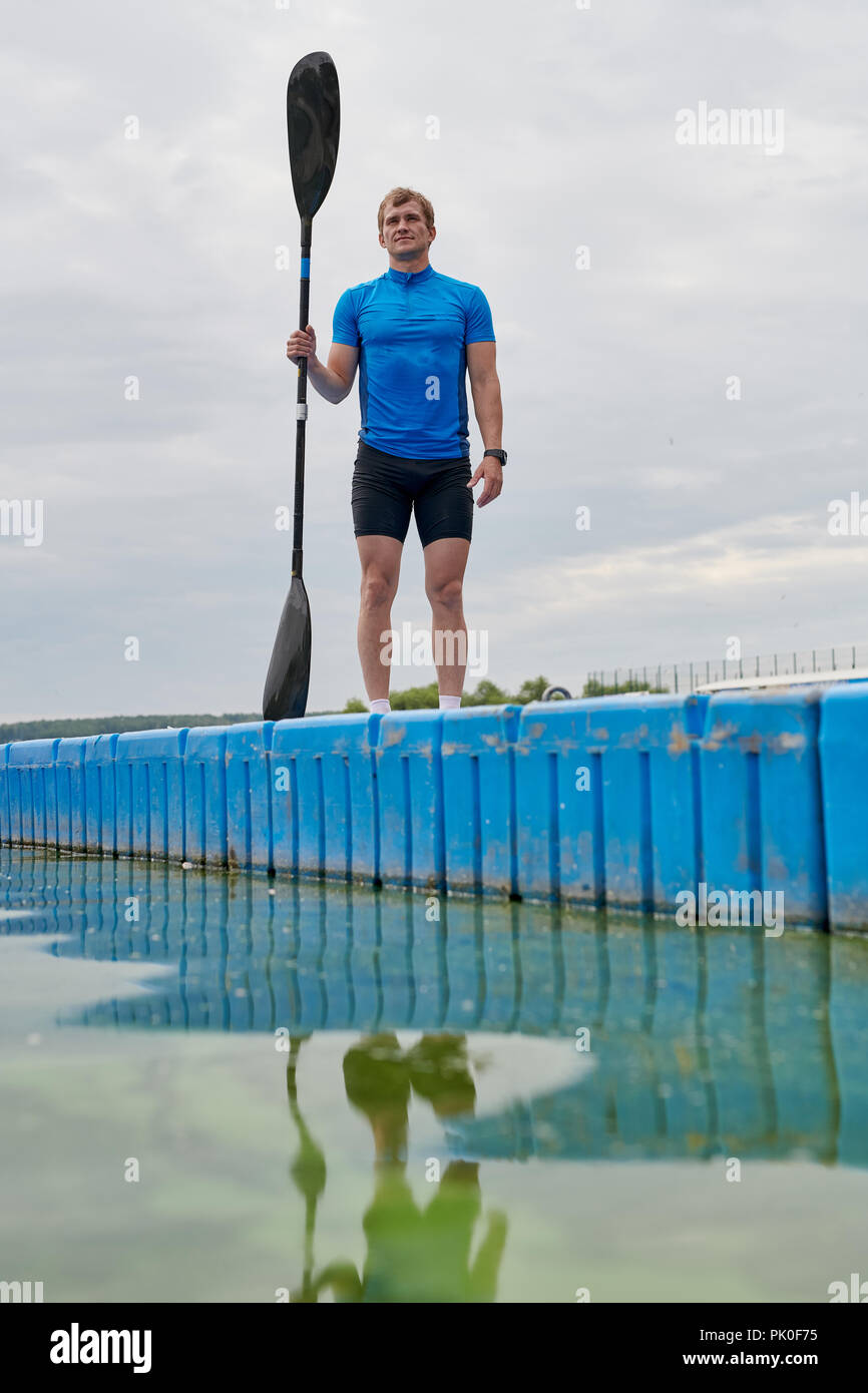 Kayaker standing with paddle Stock Photo - Alamy