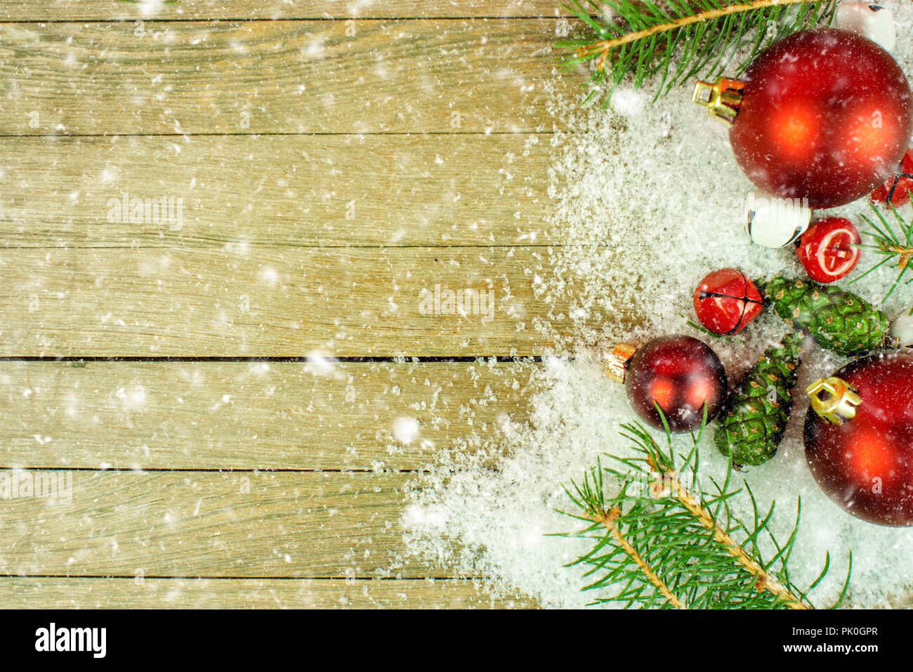 closeup of Christmas decoration with snow falling on wooden background ...
