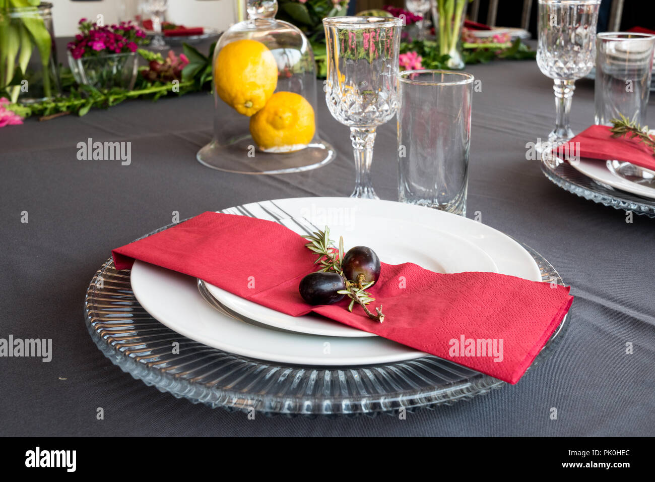 A lunch table set with under plates, lovely grey and white plates, red ...