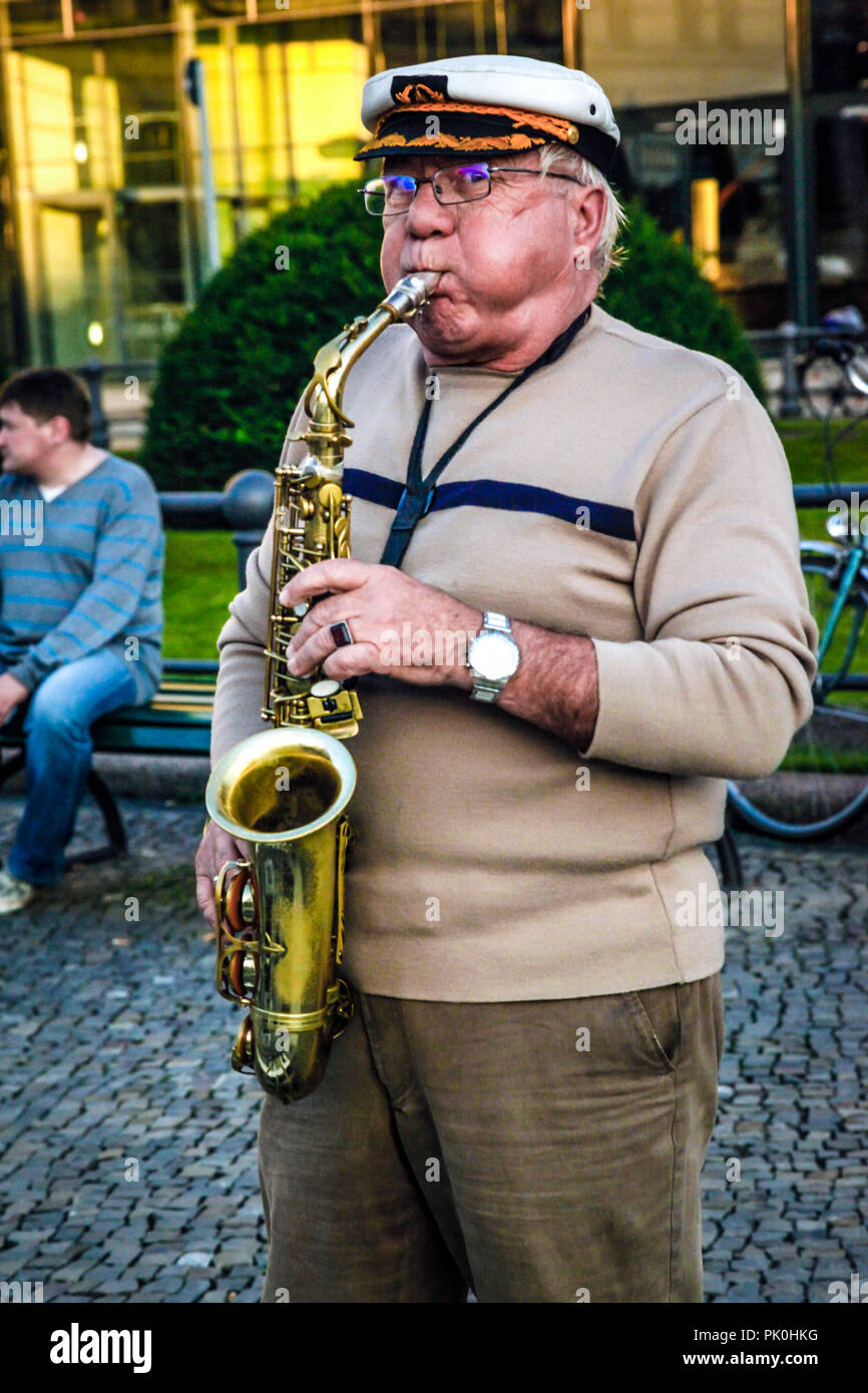 Aging busker playing the Sax does his thing in Pariser Platz in Berlin ...