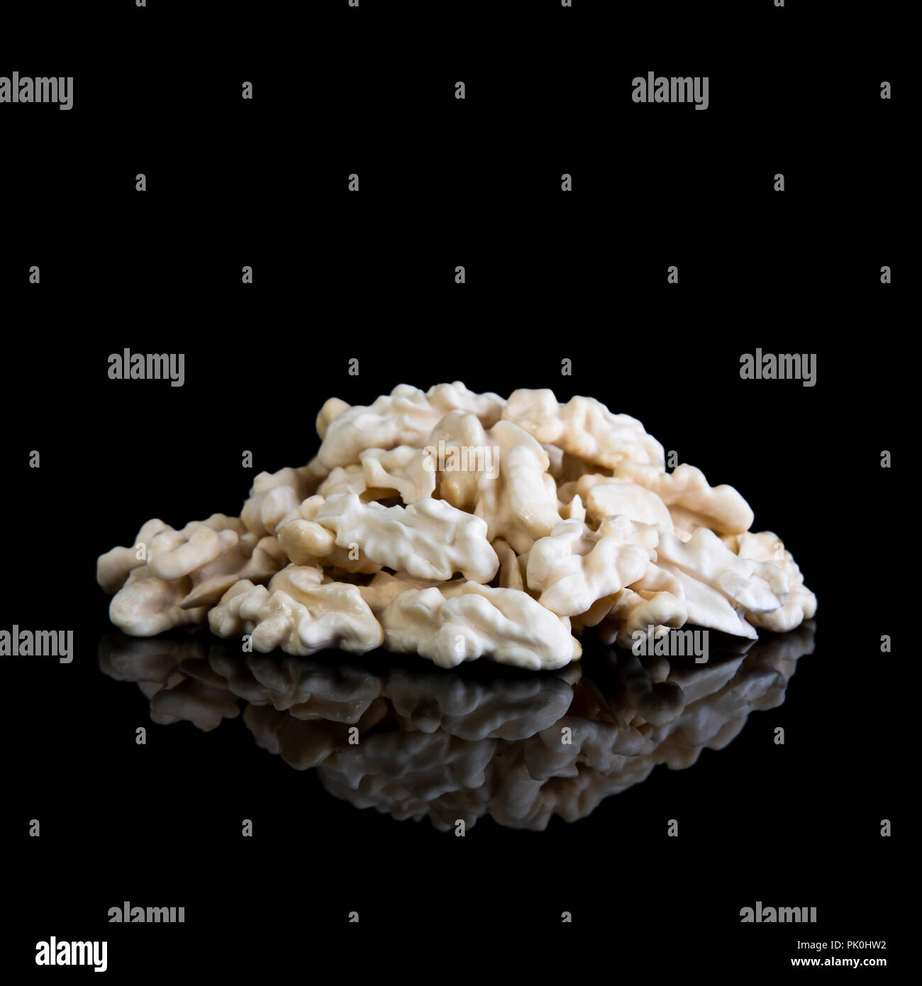 Fresh peeled walnuts on black background with shadows, fresh kernel ...