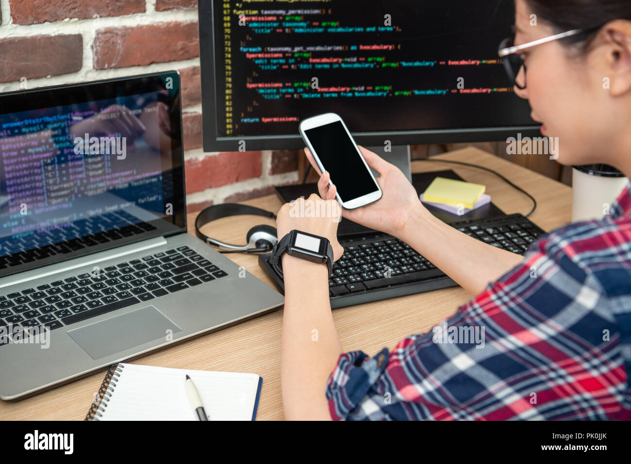 female programmer checking her phone and getting to know the accurate ...