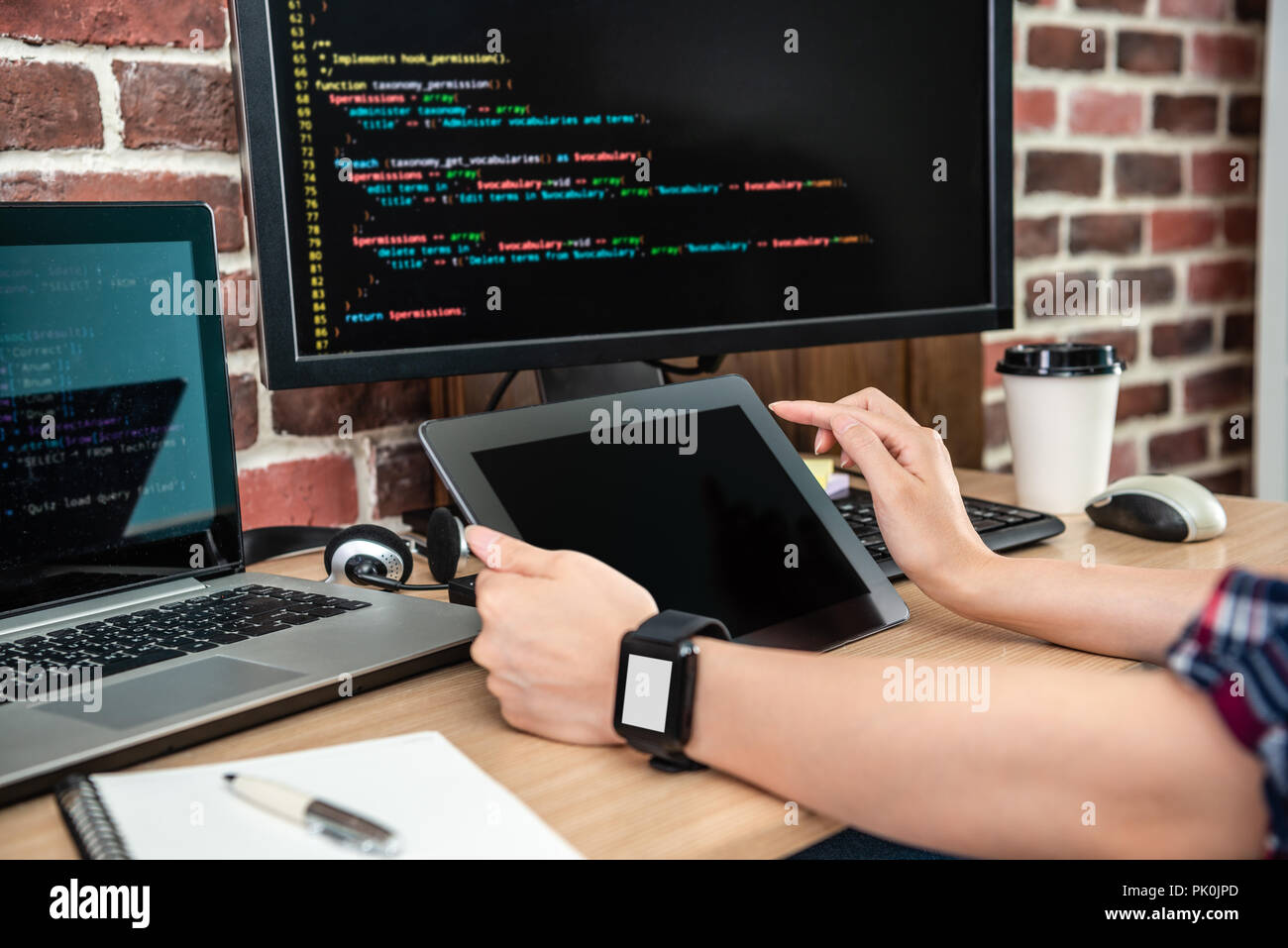 the closeup view of using tablet on the desk with other electronic ...