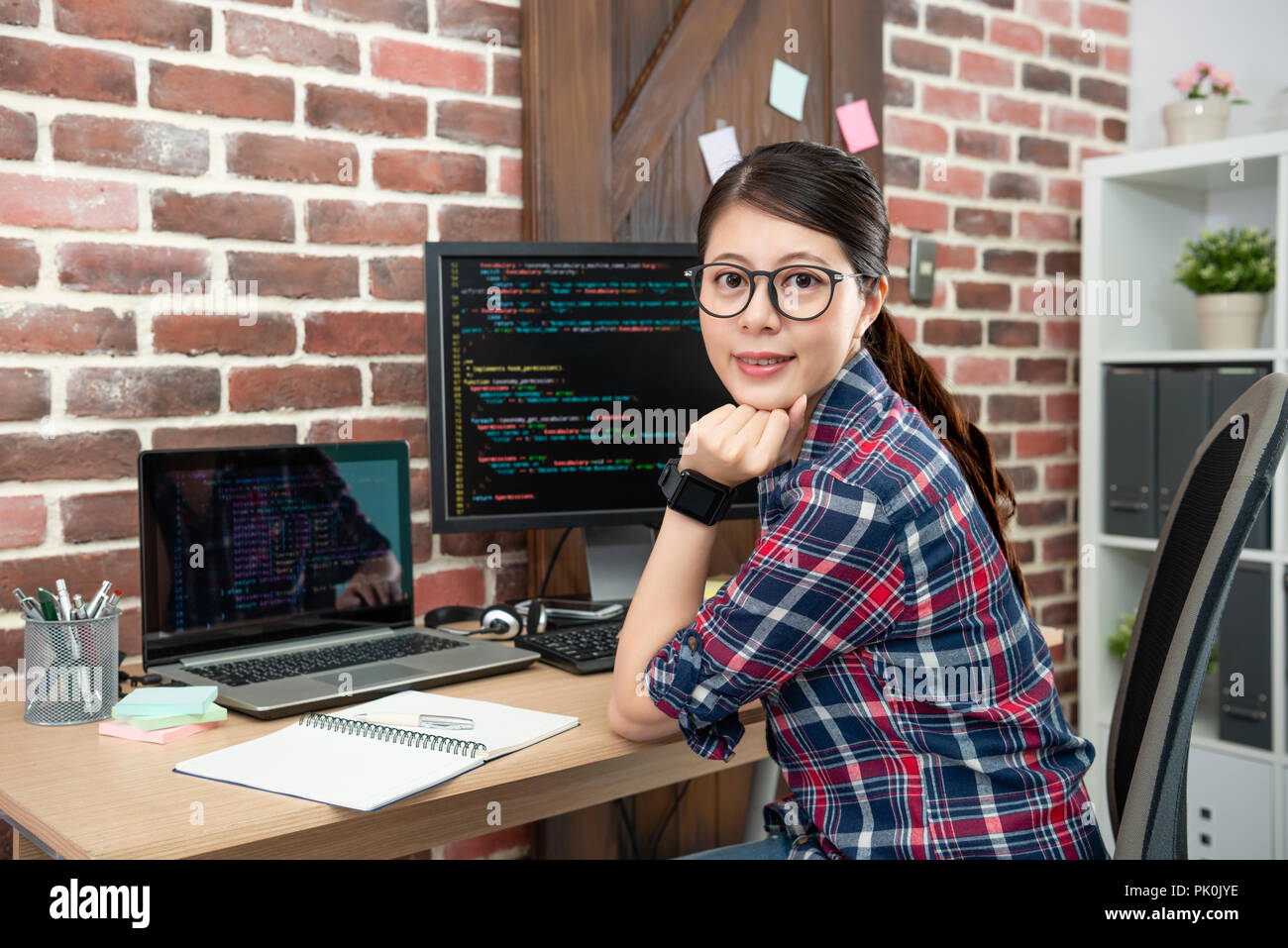 Portrait Of Young Asian Female Programmer Sitting In Her Working Office And Smiling Friendly