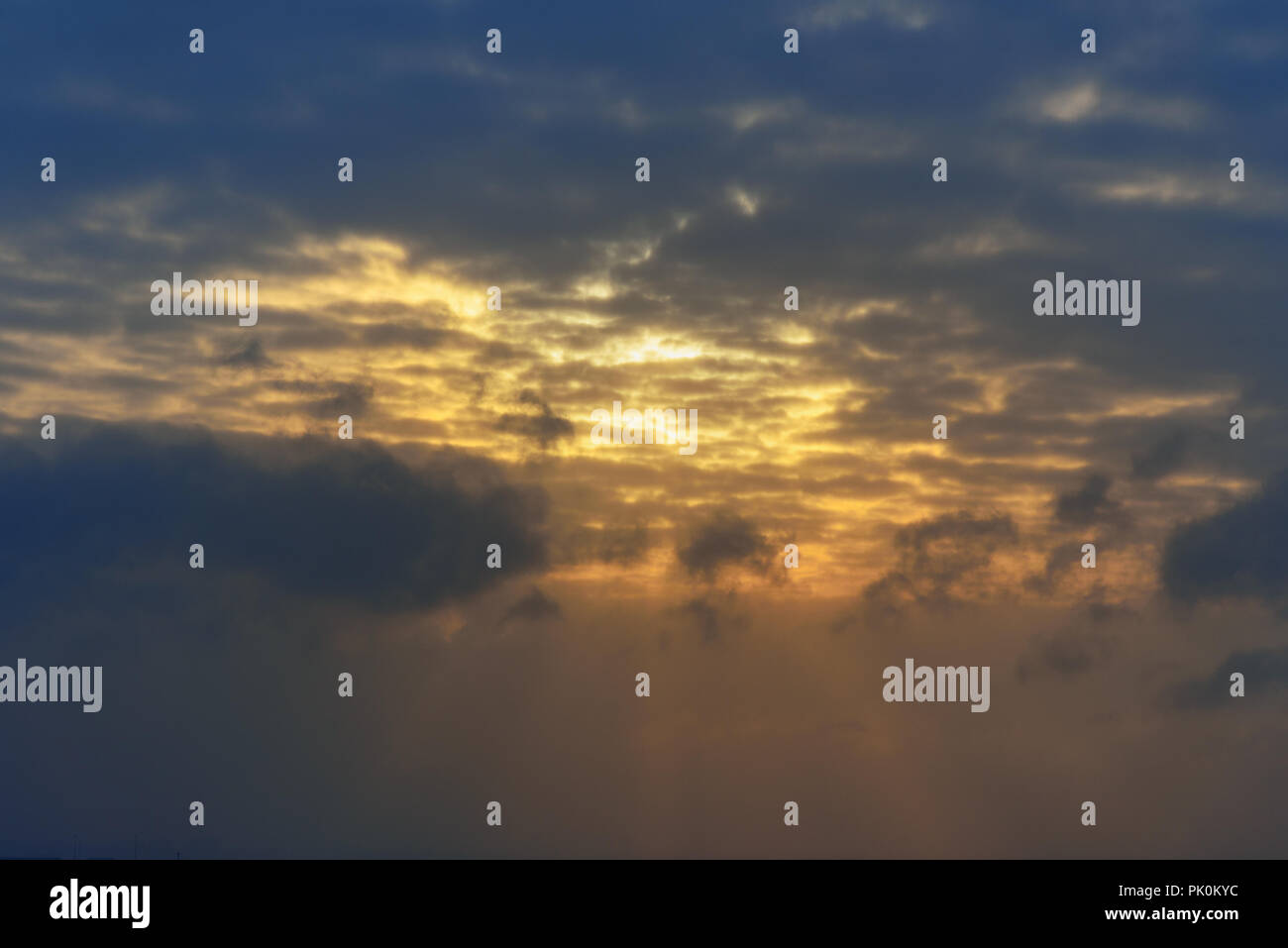 Sun rays breaking through the dark clouds at sunset. Background Stock ...