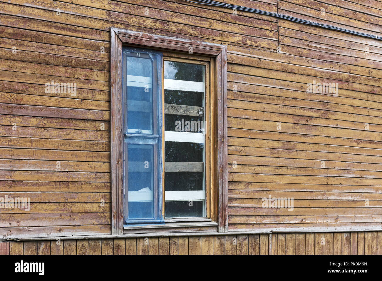 boarded up and broken window on weathered wooden wall of abandoned old ...