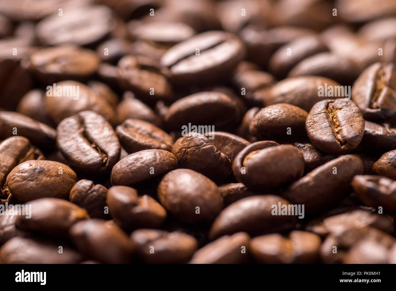 Roasted organic whole dark coffee beans, close up Stock Photo - Alamy