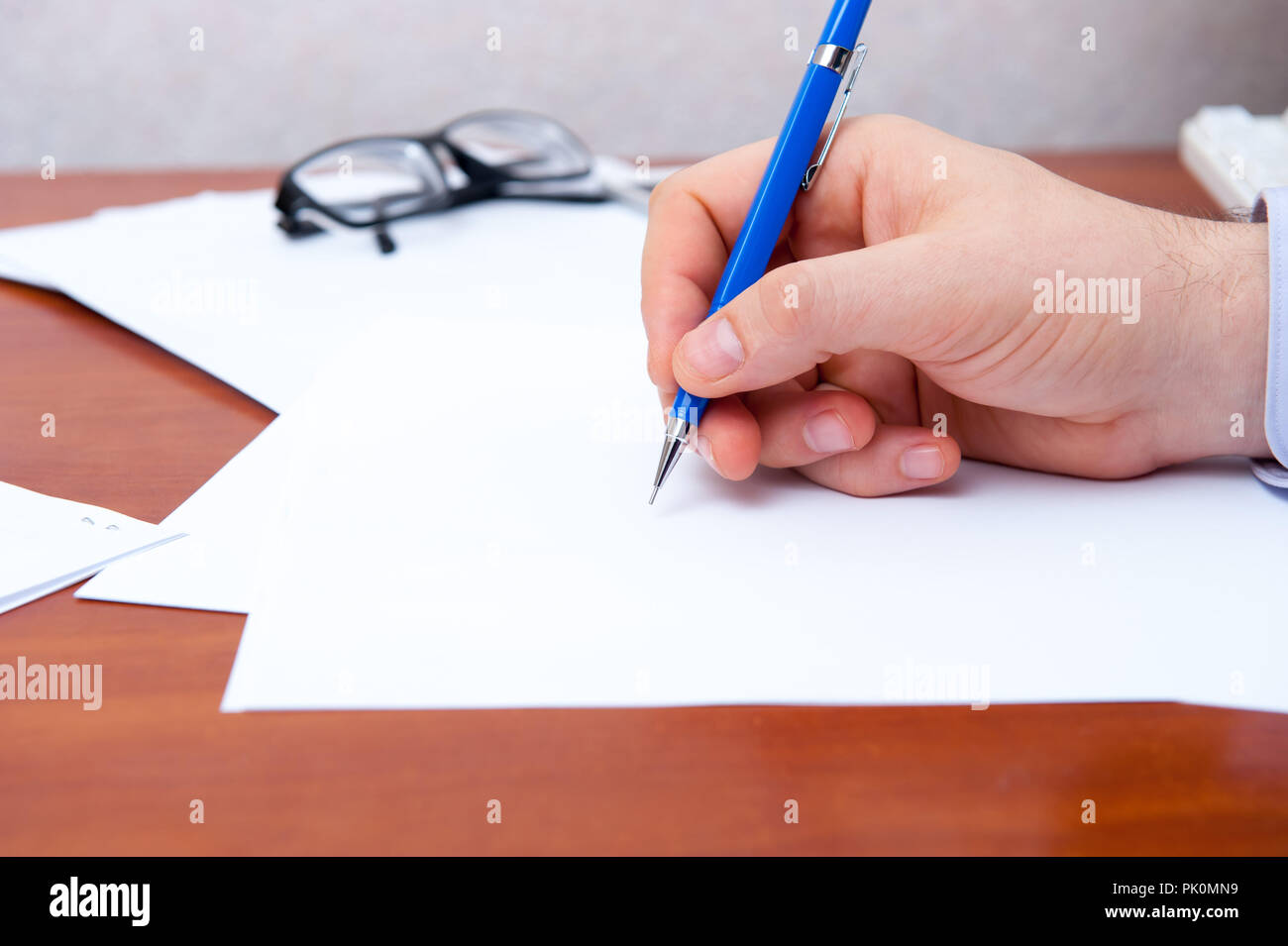 Hand with pen on desk signs documents Stock Photo - Alamy