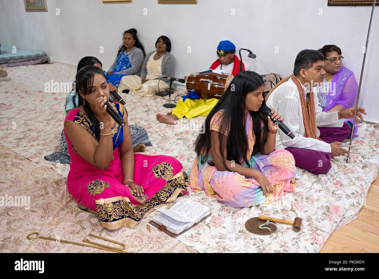 A small congregation of Hindu worshippers singing during services in a ...