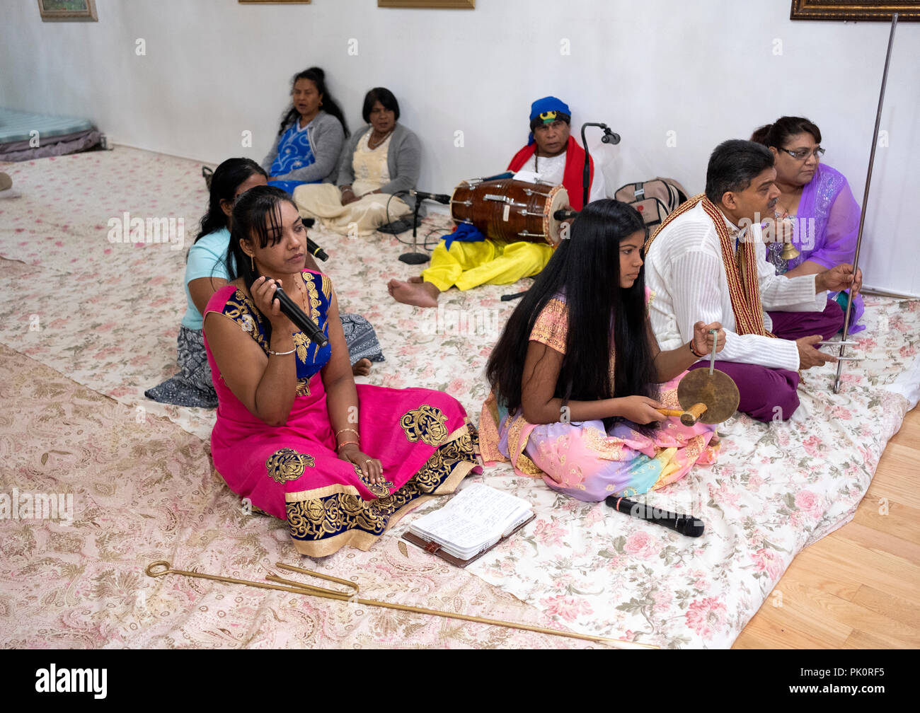 A small congregation of Hindu worshippers praying during services in a ...