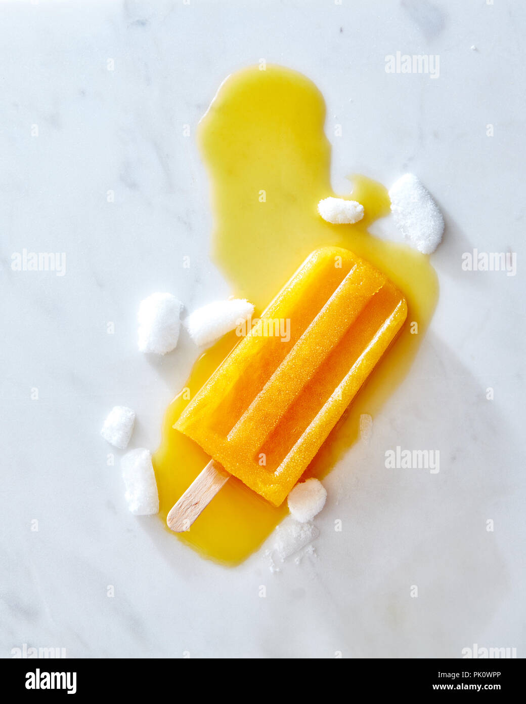 Composition of pieces ice and melting ice cream on a stick with ...